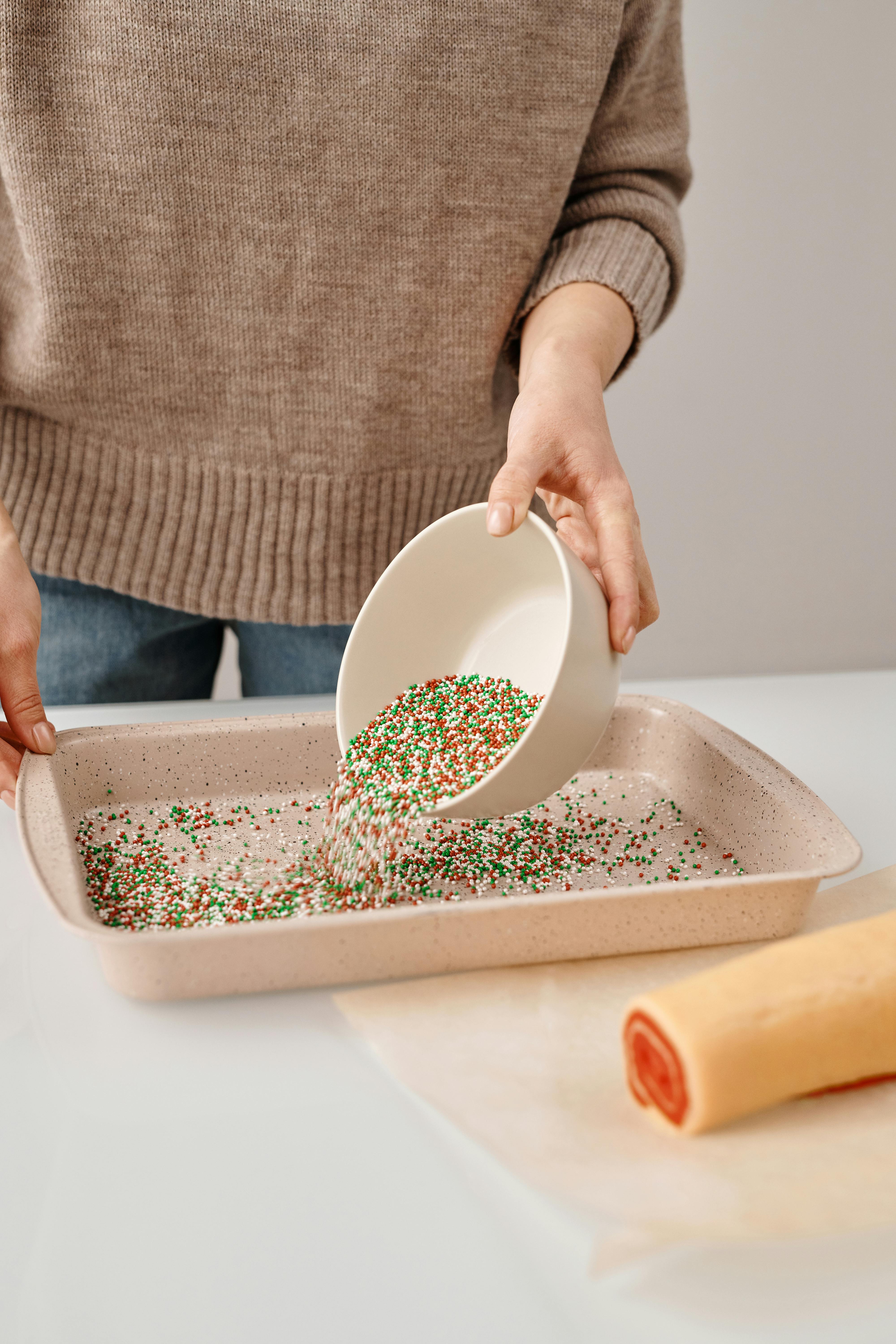 Person Pouring Colorful Sprinkles on a Tray · Free Stock Photo