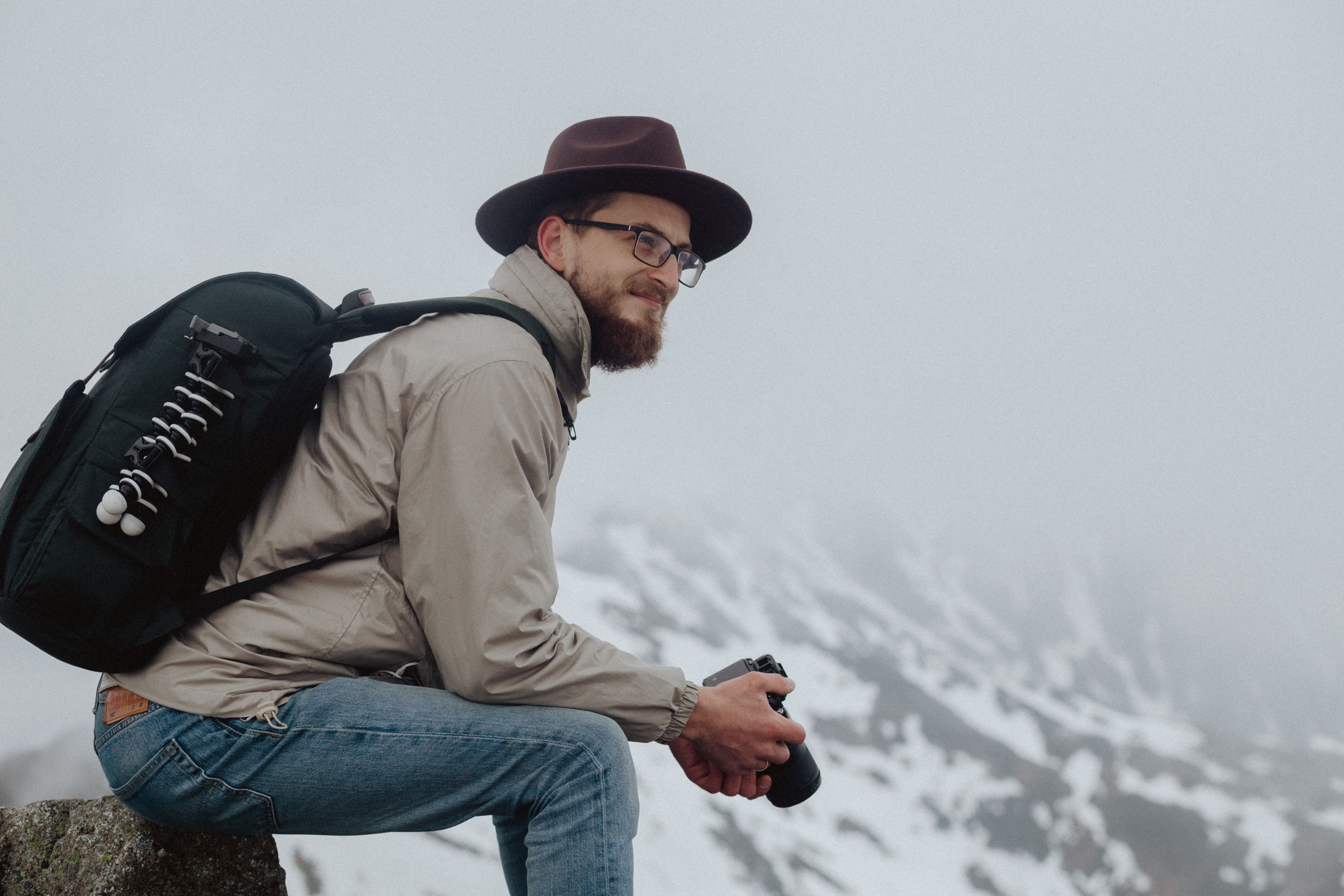 A Man Sitting While Carrying a Backpack · Free Stock Photo