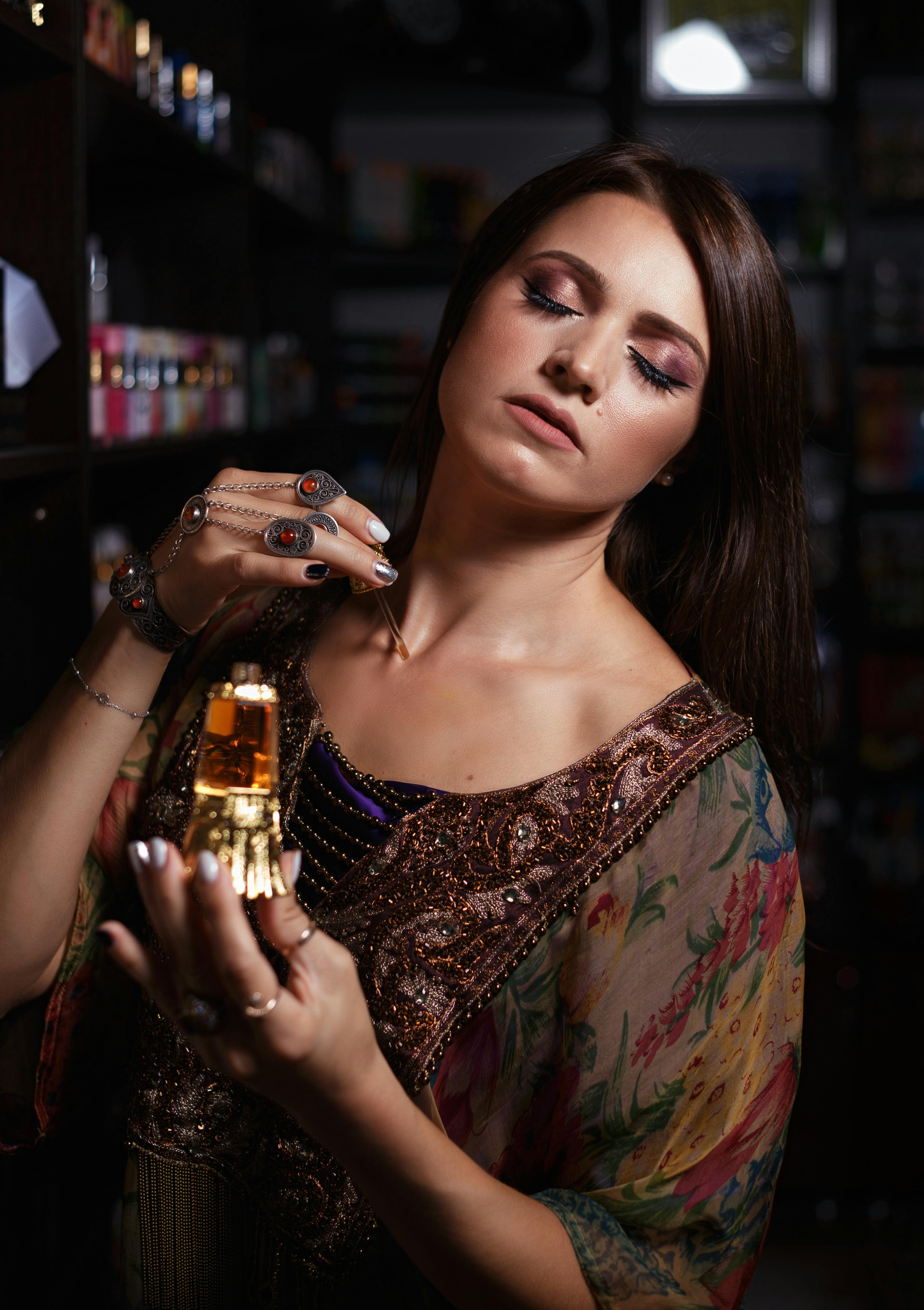 Tranquil woman with bottle of perfume in hand · Free Stock Photo