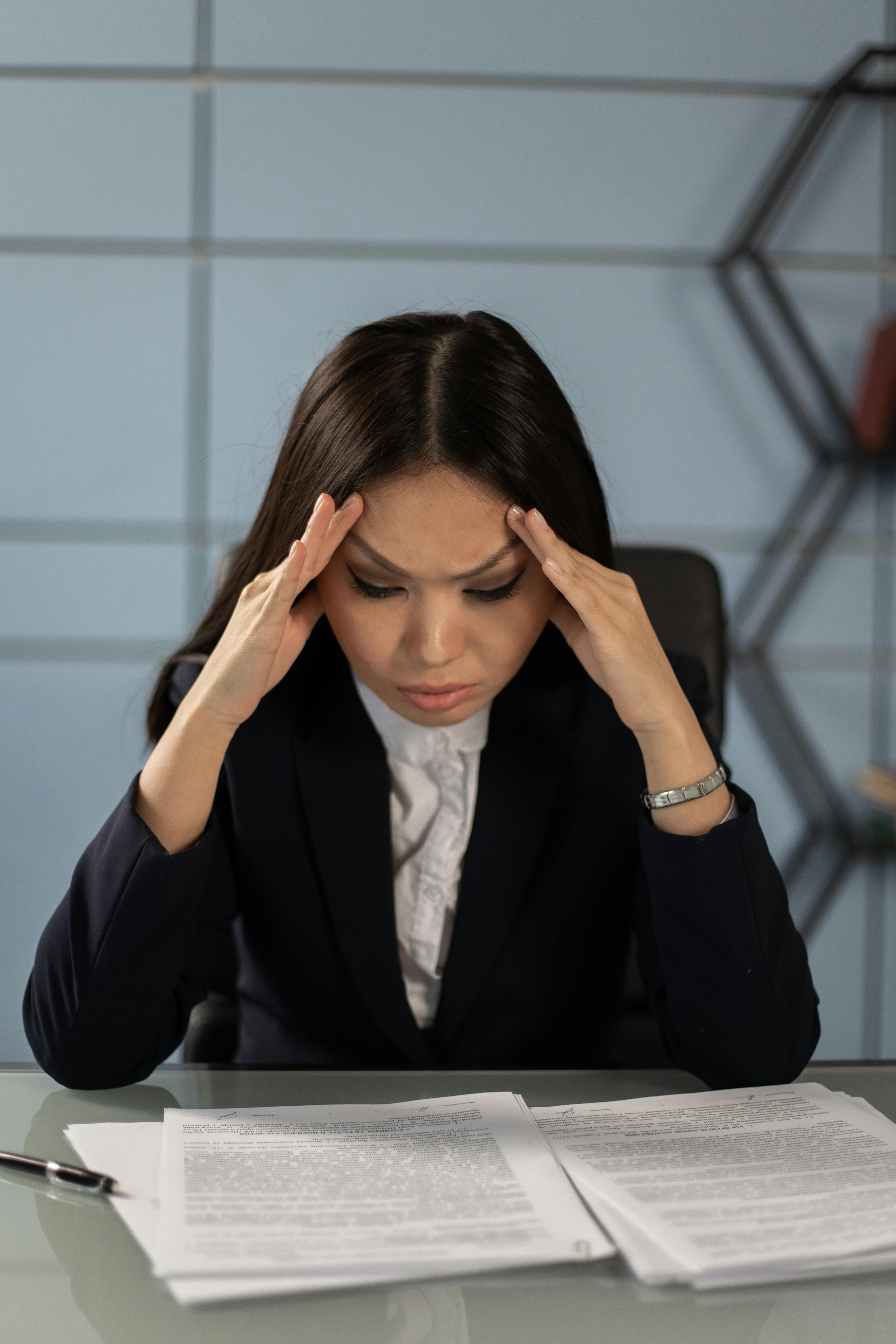 Woman in Black Blazer Holding Her Face Looking Stressed · Free Stock Photo