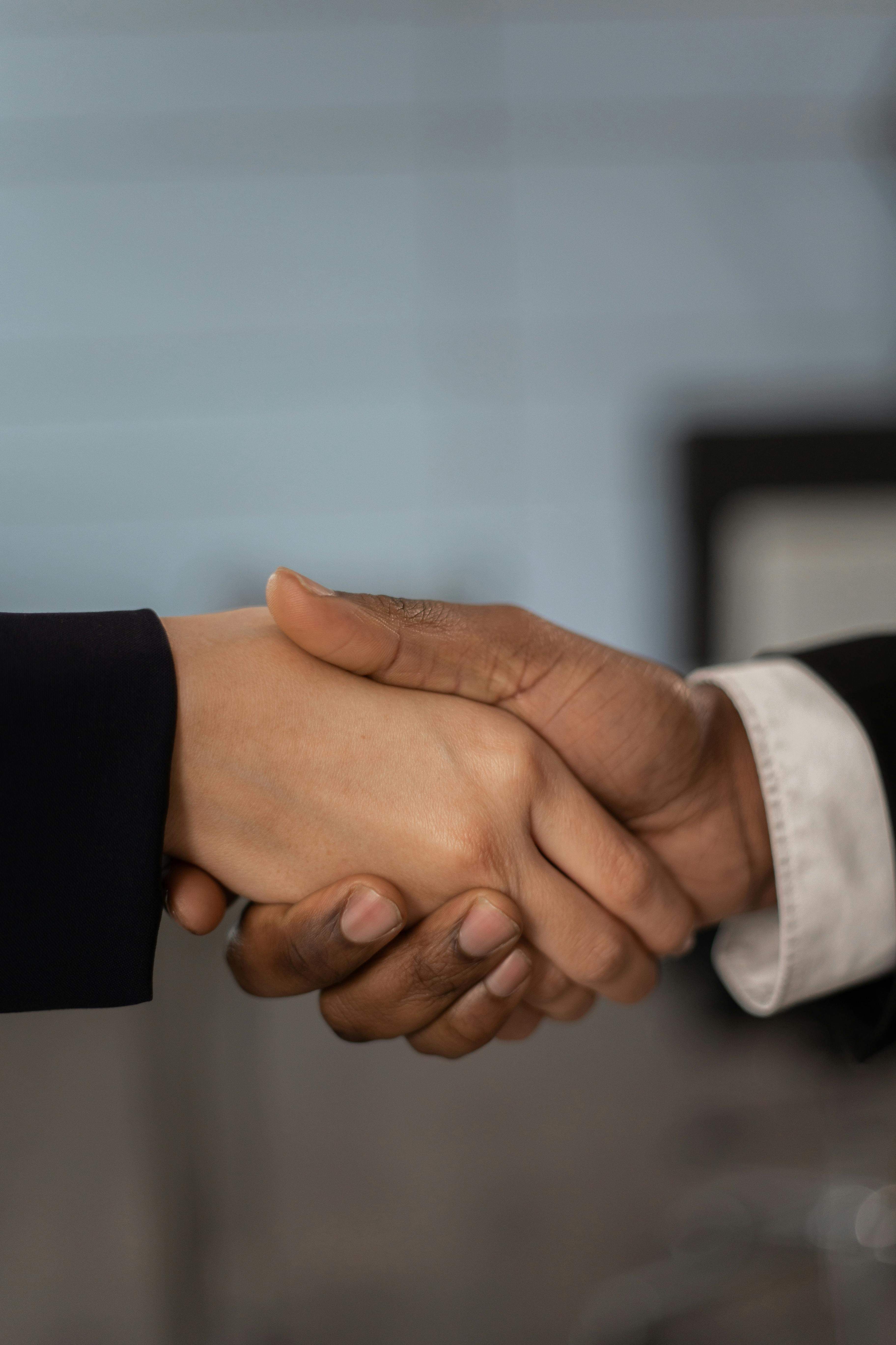 Close-Up View of Two People Shake Hands · Free Stock Photo