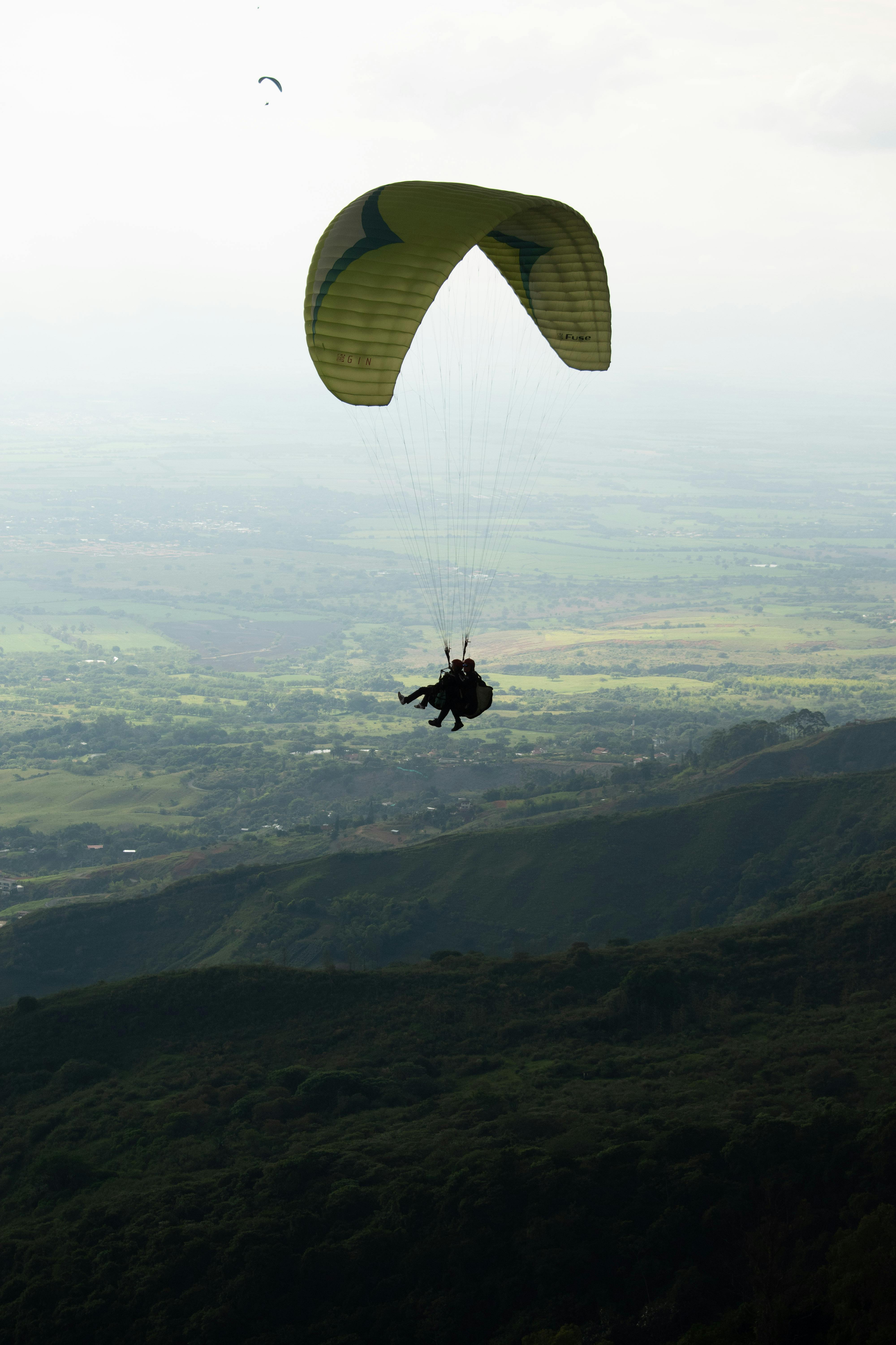 Person Riding Parachute Above Ocean · Free Stock Photo
