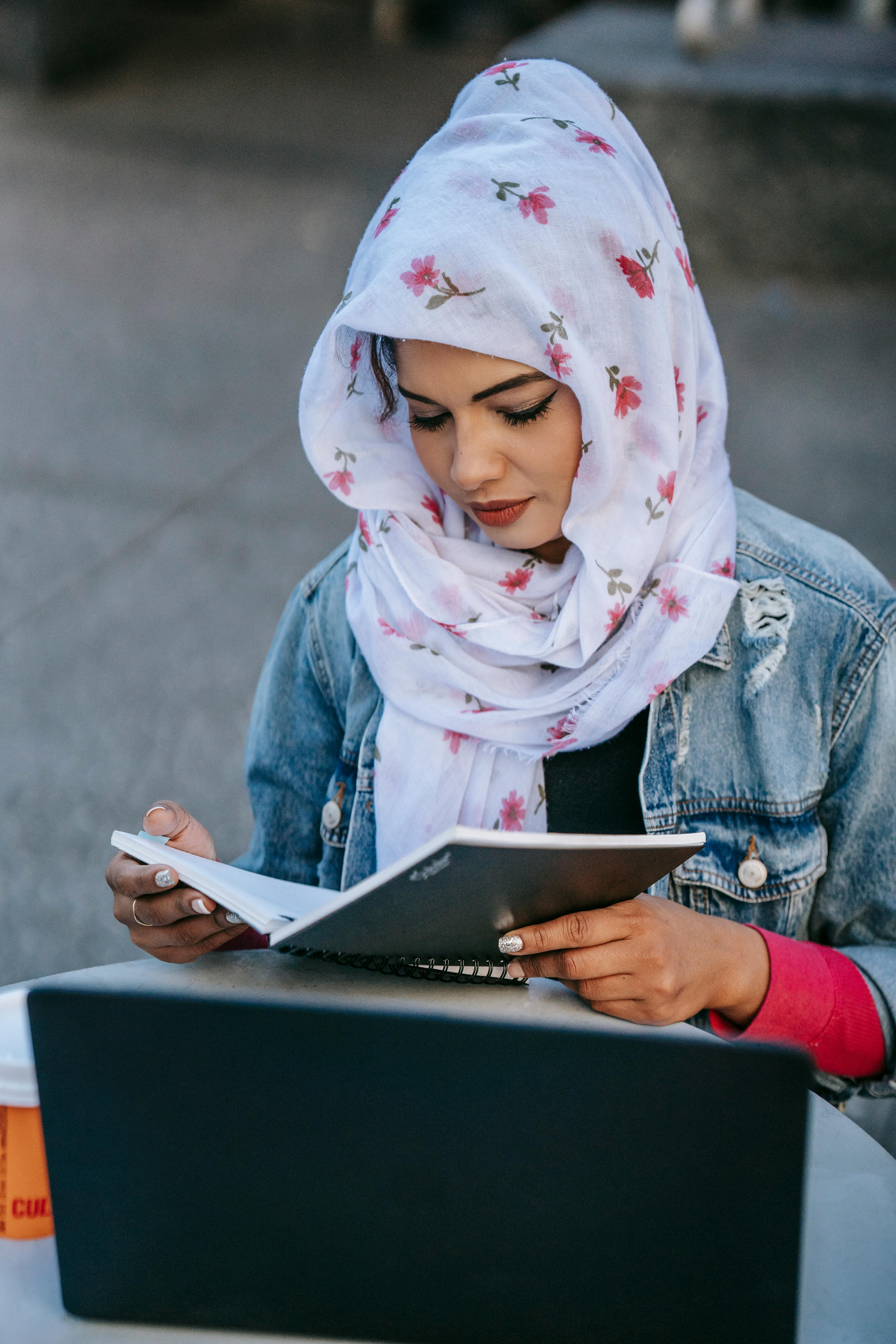 Focused woman reading notes in notebook · Free Stock Photo