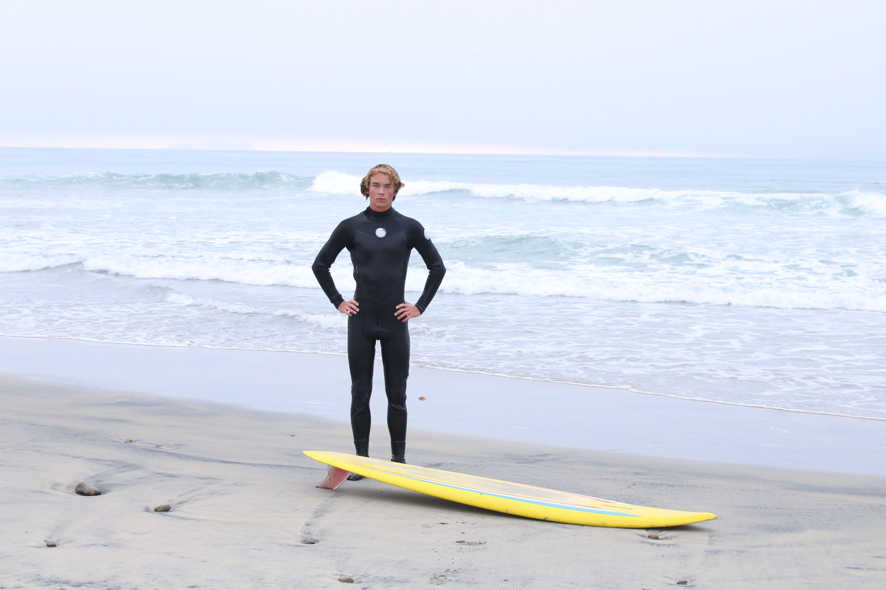 A Man Wearing Wetsuit Standing at the Beach · Free Stock Photo