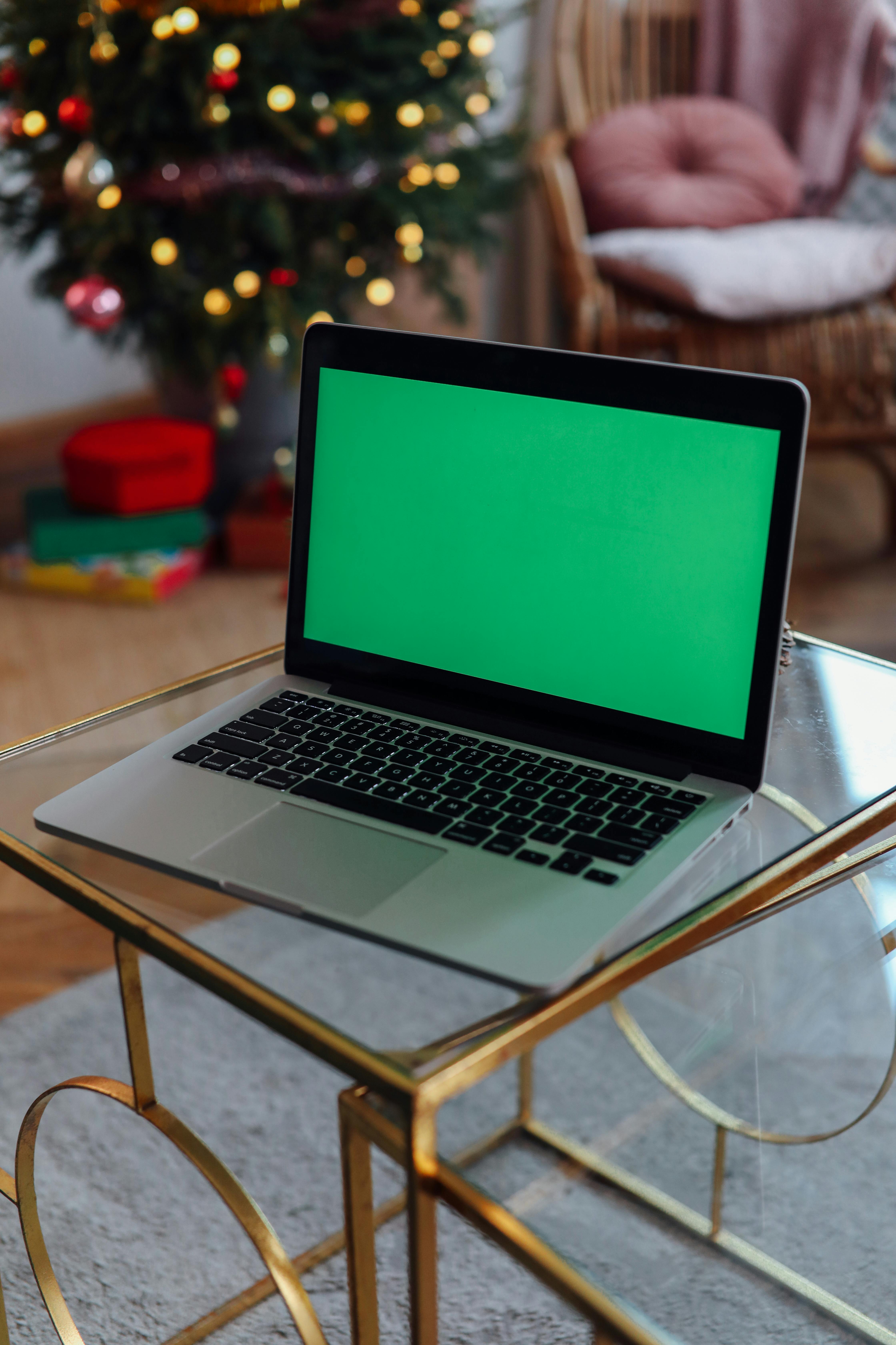 Laptop with Green Screen on Glass Table · Free Stock Photo