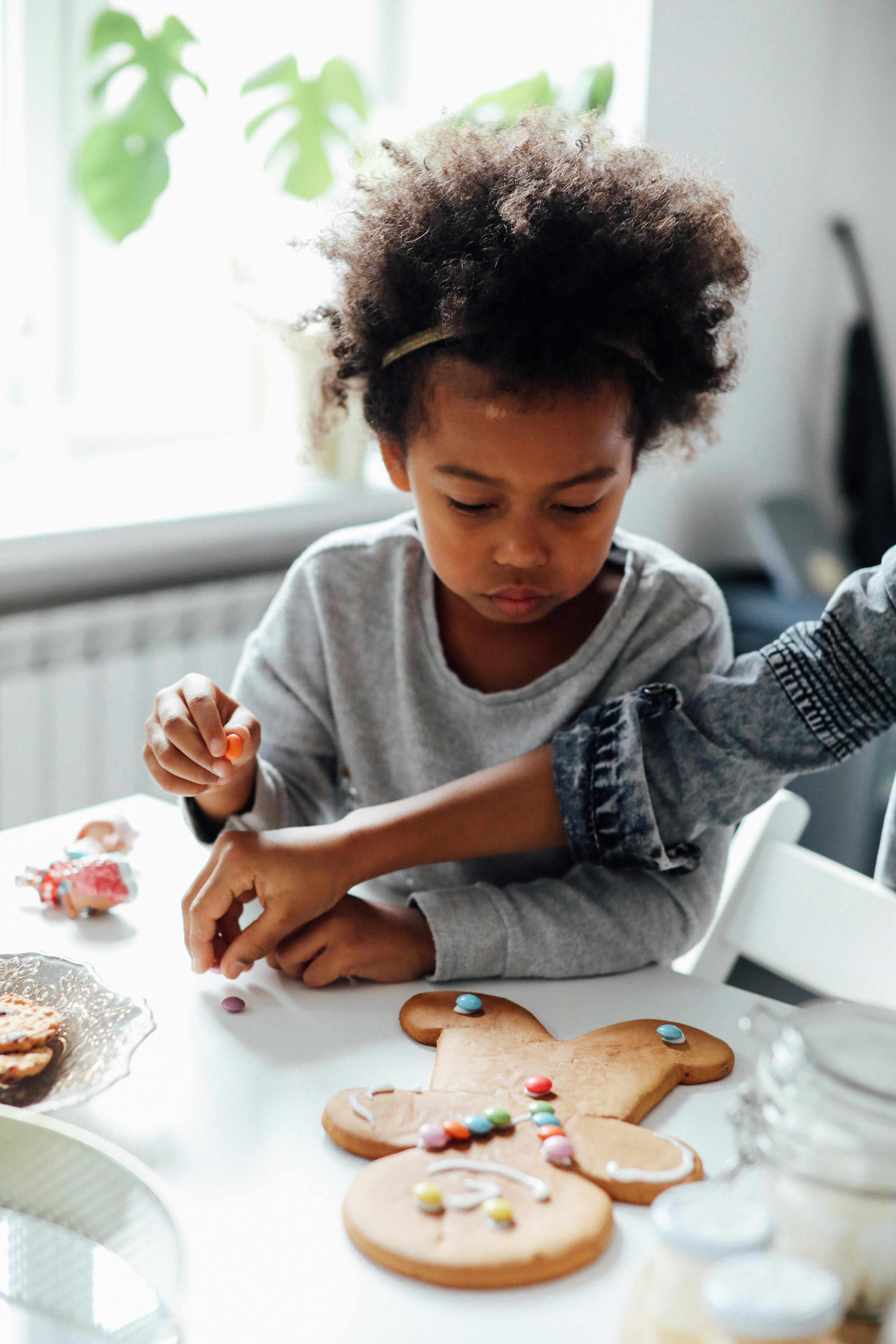 Girl In Gray Long Sleeve Shirt Decorating Cookies · Free Stock Photo