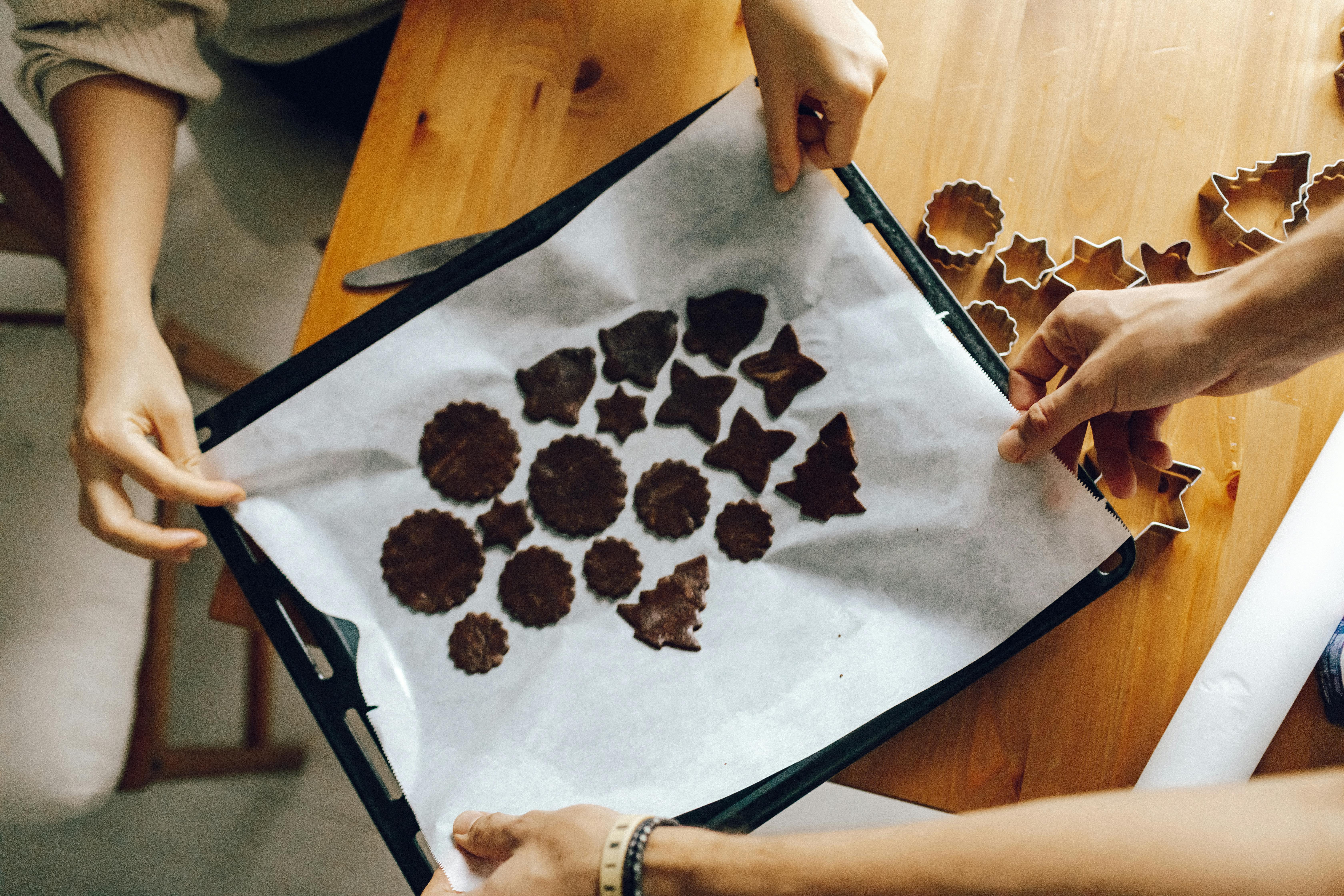 Hands Holding White Wax Paper with Brown Dough in Various Shapes · Free ...