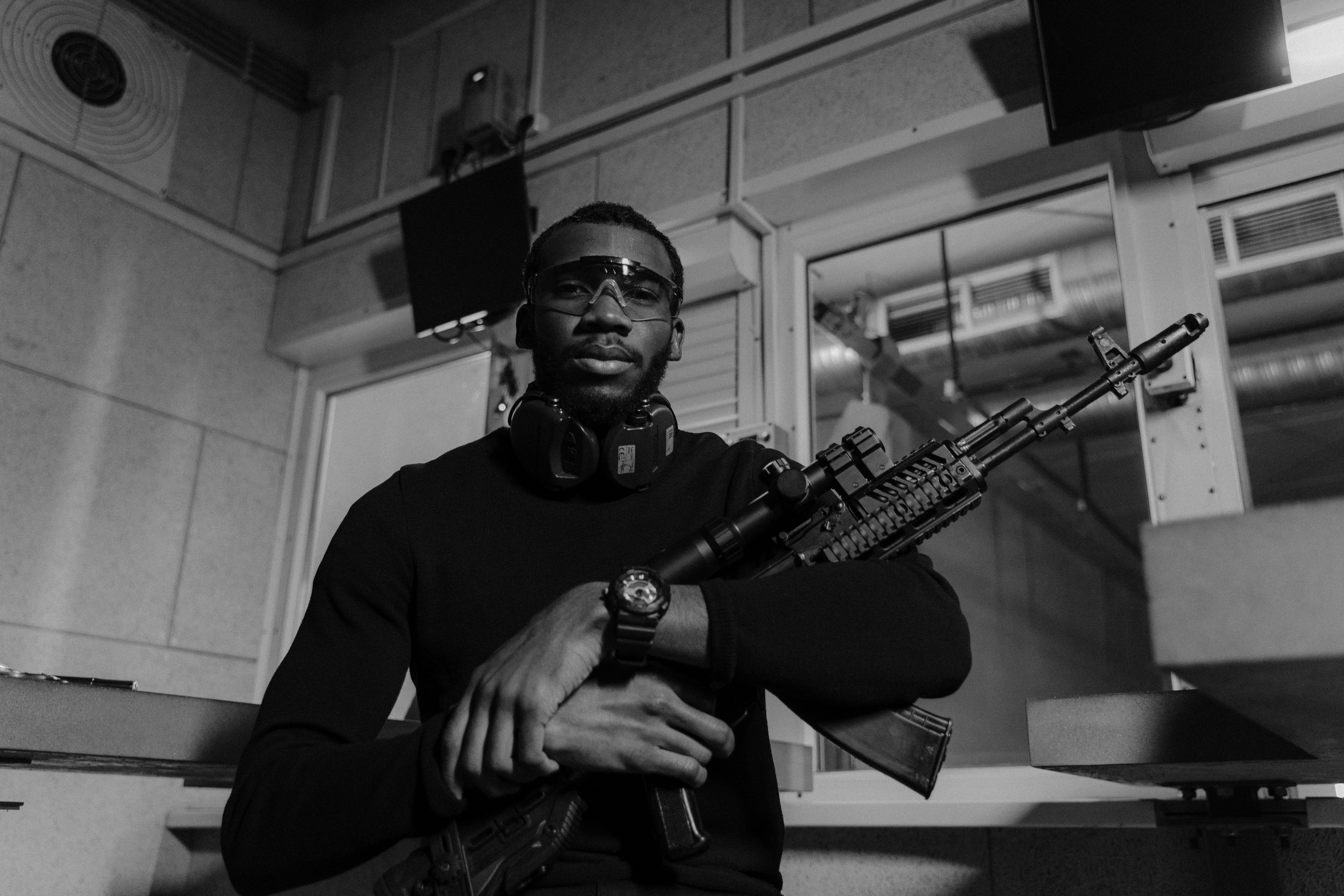 Grayscale Photography of Man in Long Sleeves Shirt Holding Rifle while ...