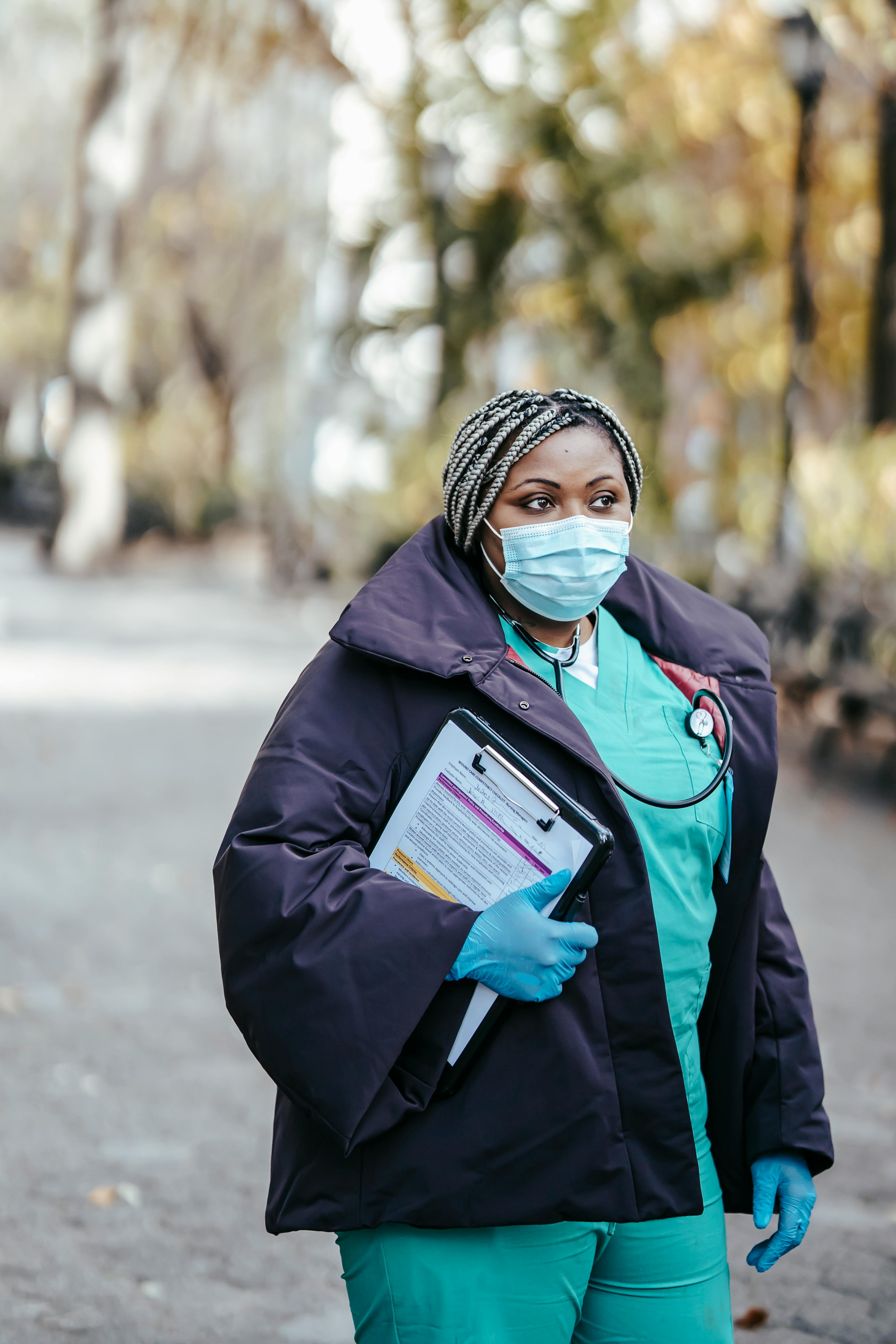 African American woman nurse walking in pandemic with papers · Free ...
