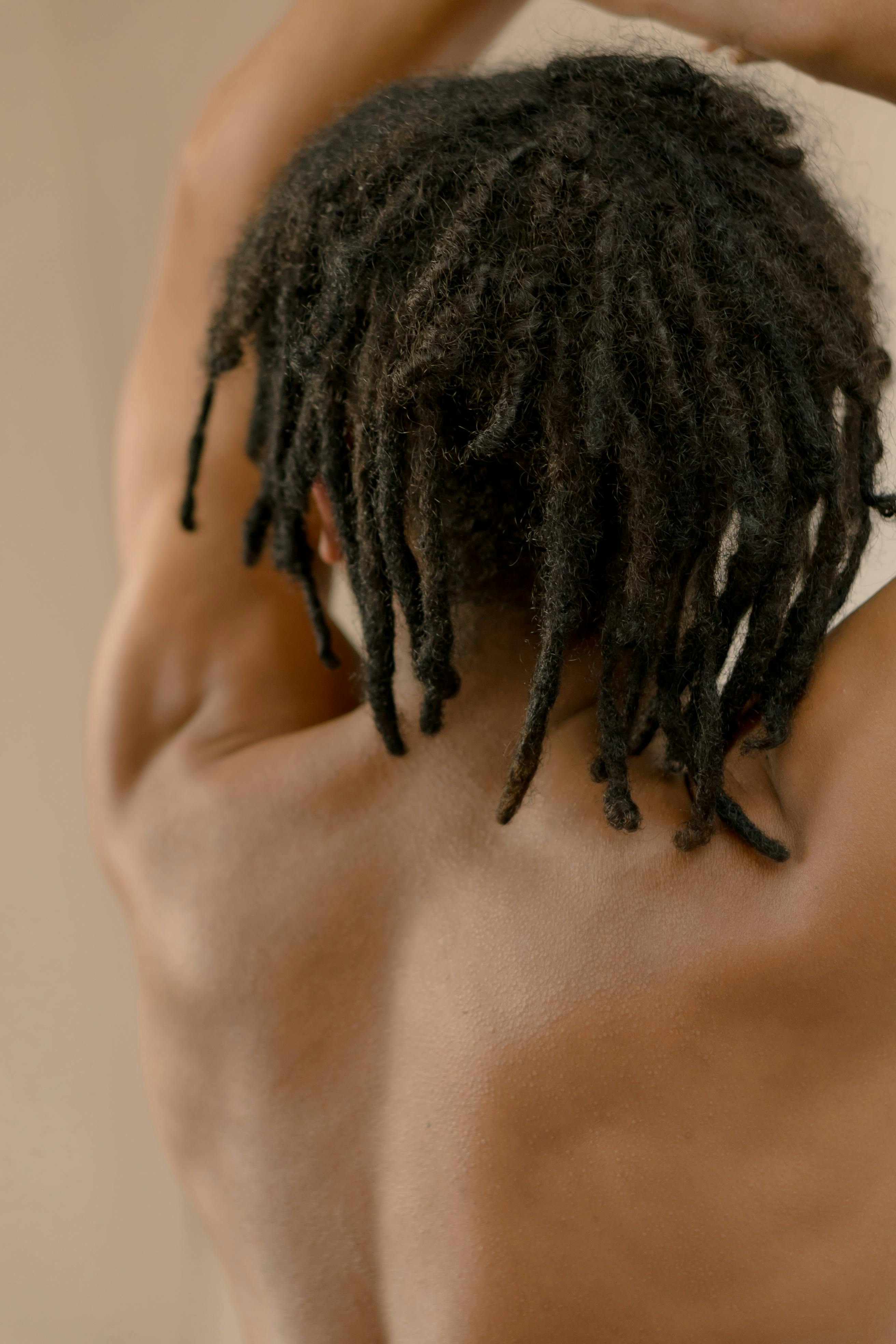 The Back View of a Shirtless Man with Dreadlocks · Free Stock Photo
