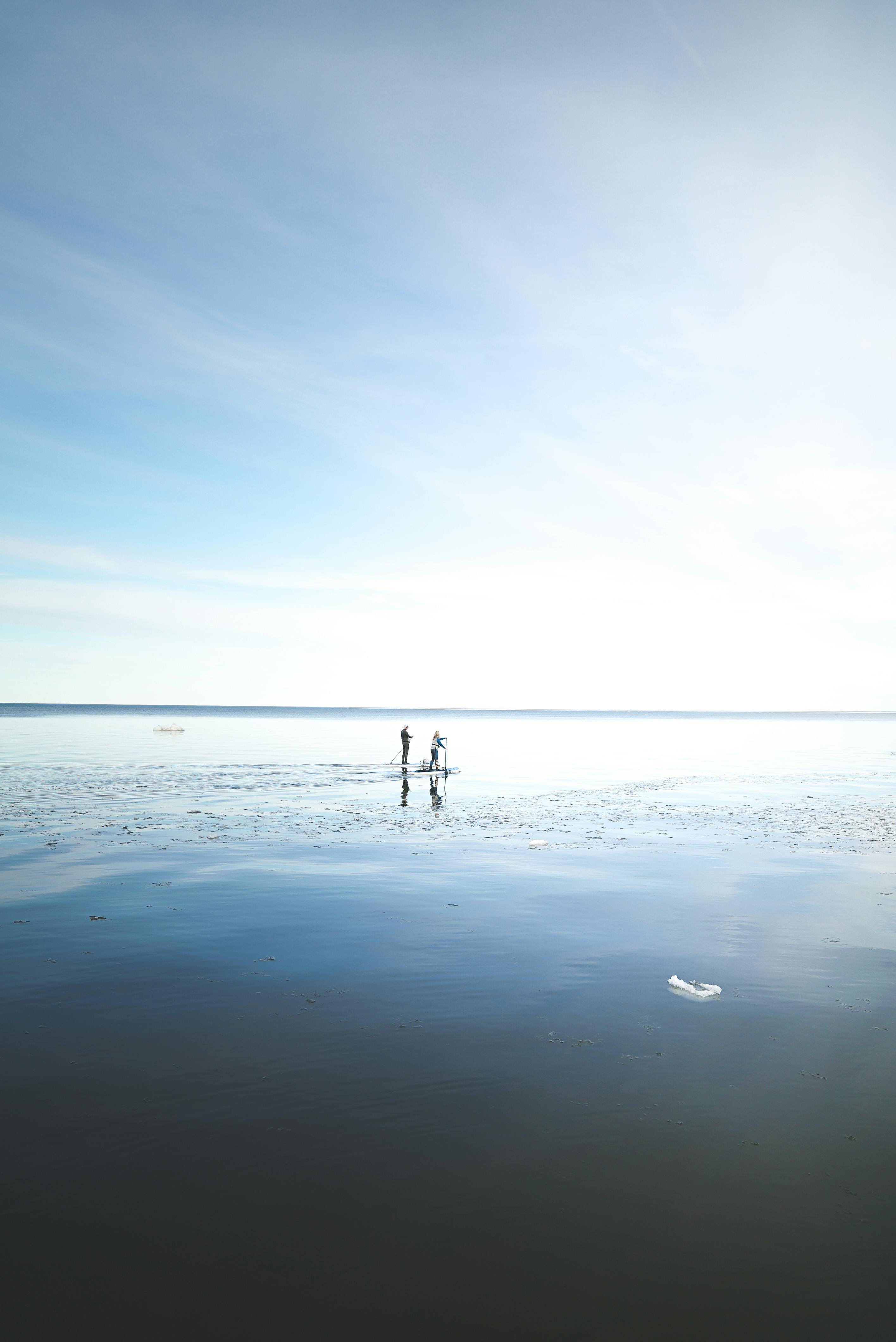 Anonymous traveler rowing on paddleboard in peaceful sea · Free Stock Photo