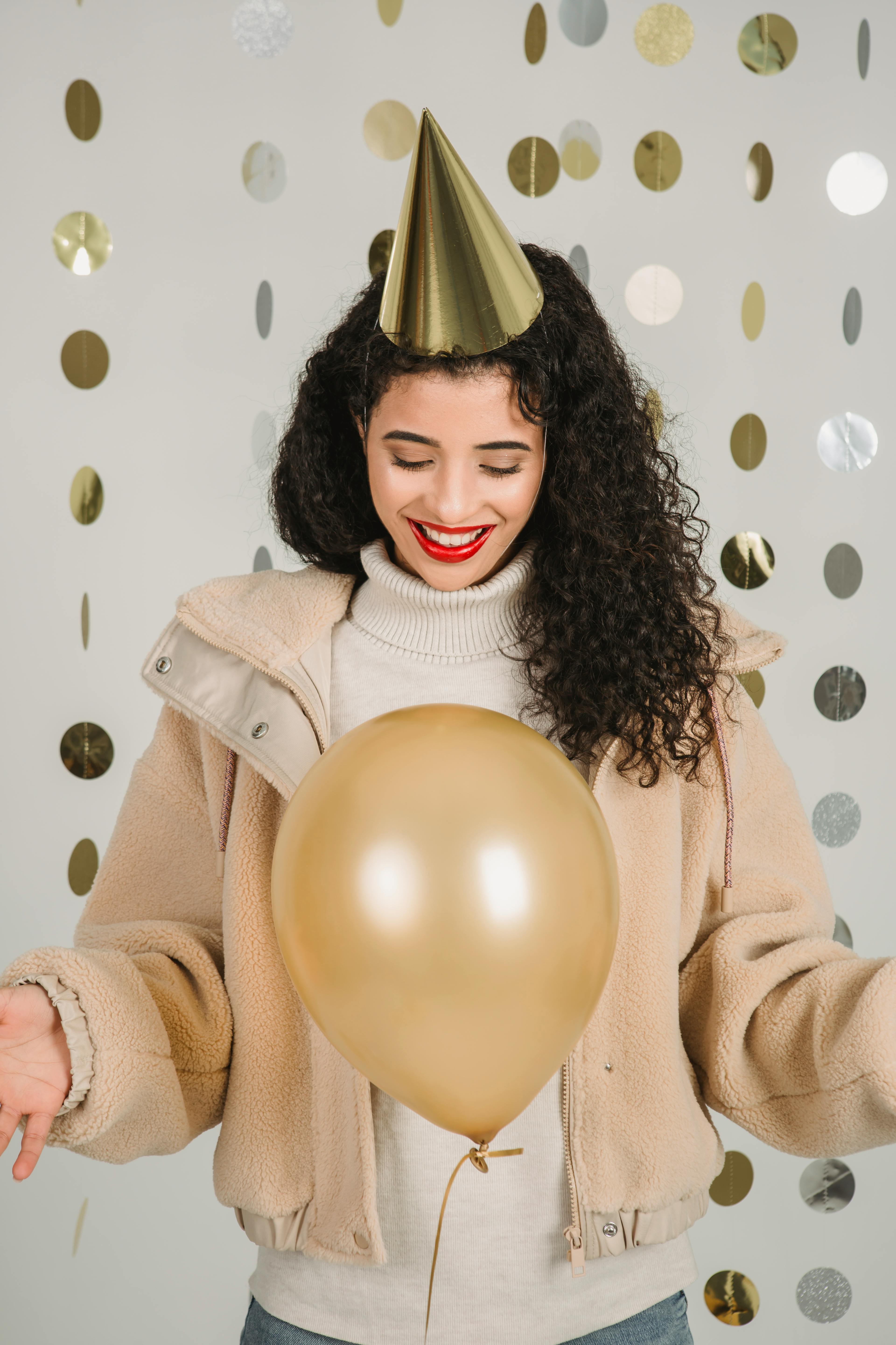 Smiling woman with balloon in decorated room · Free Stock Photo