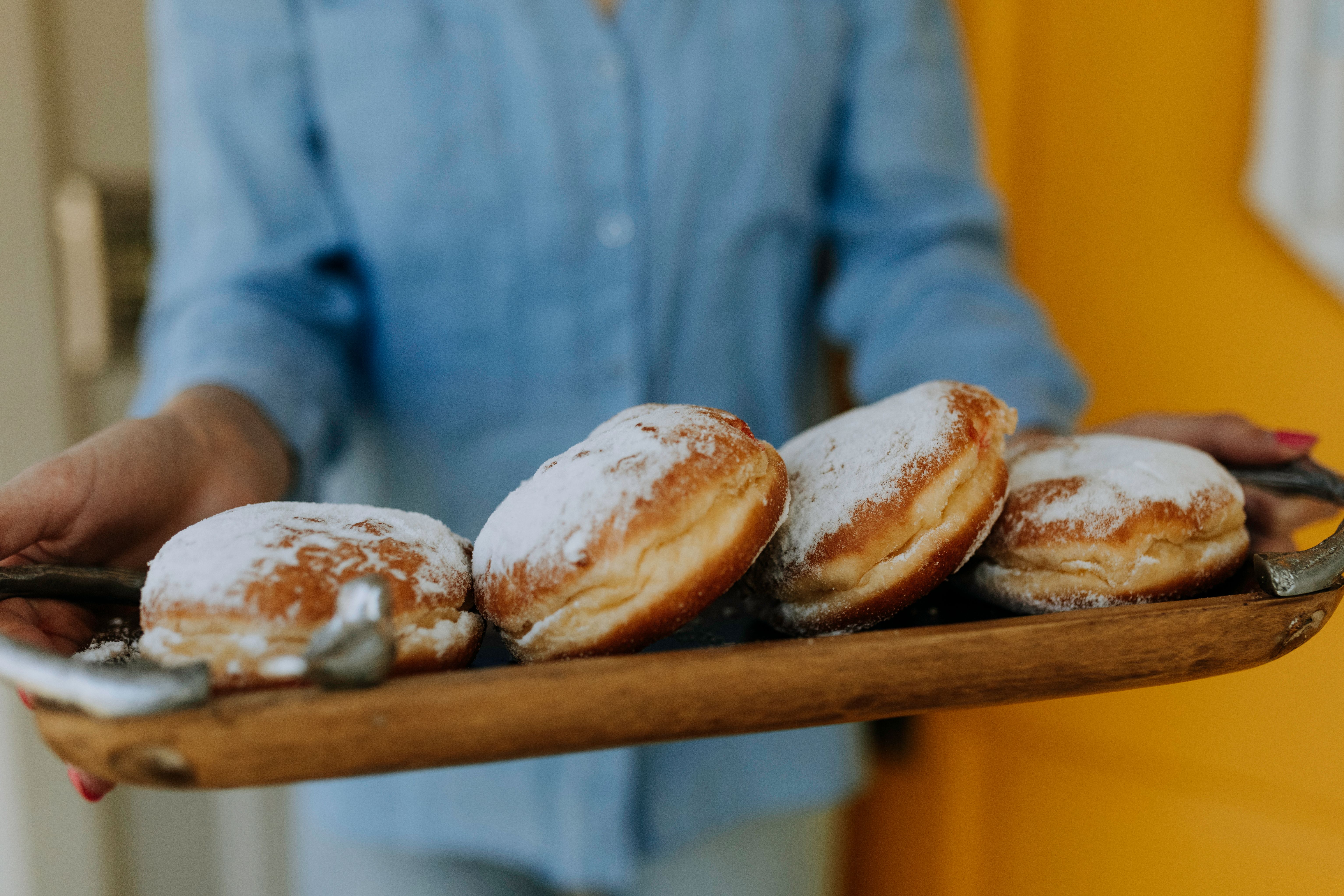 Photo Of Person Carrying Tray Of Doughnuts · Free Stock Photo