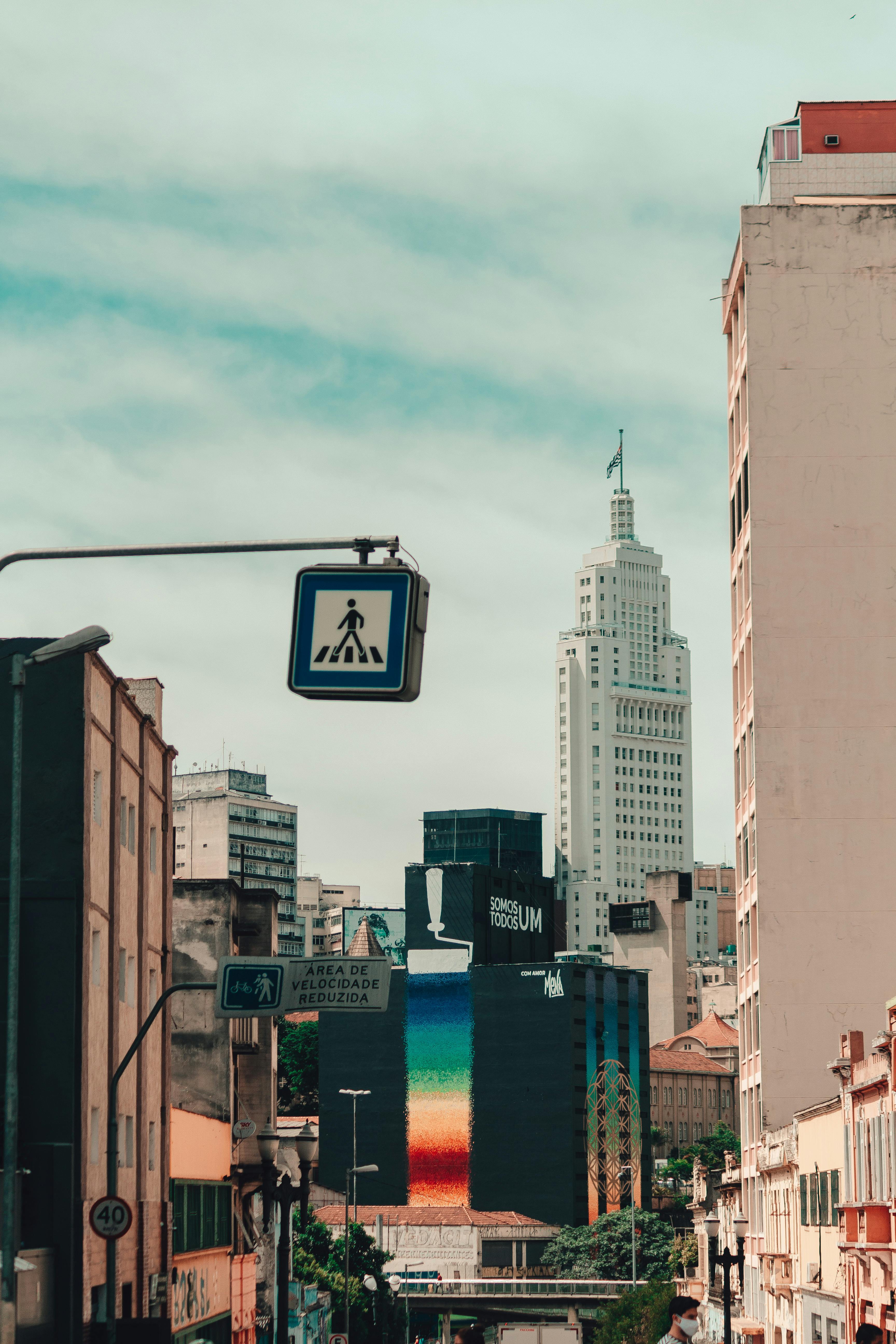 Street with big modern buildings and hanging road signs · Free Stock Photo