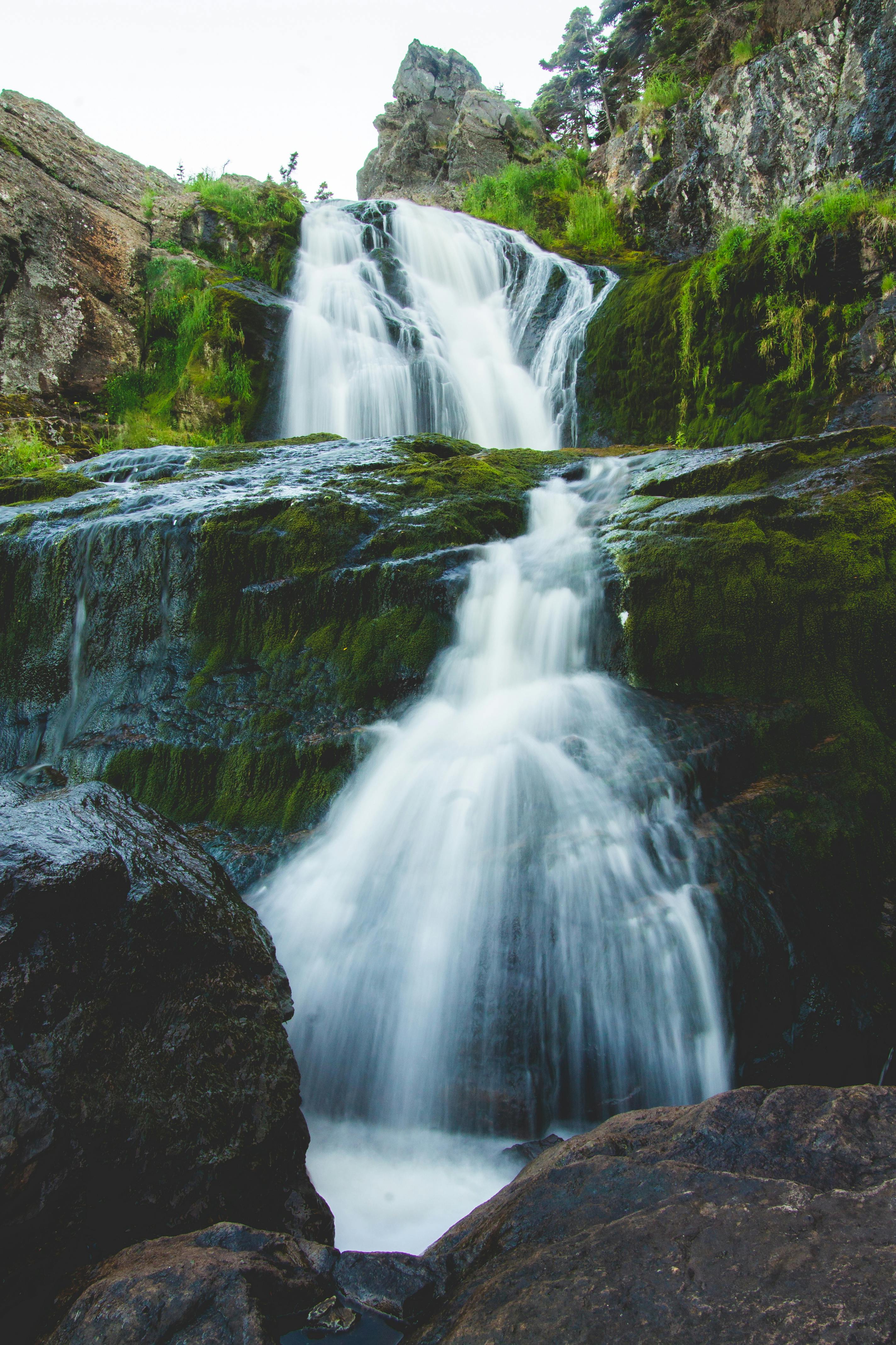Anonymous tourist enjoying waterfall streaming in rocky ravine · Free ...