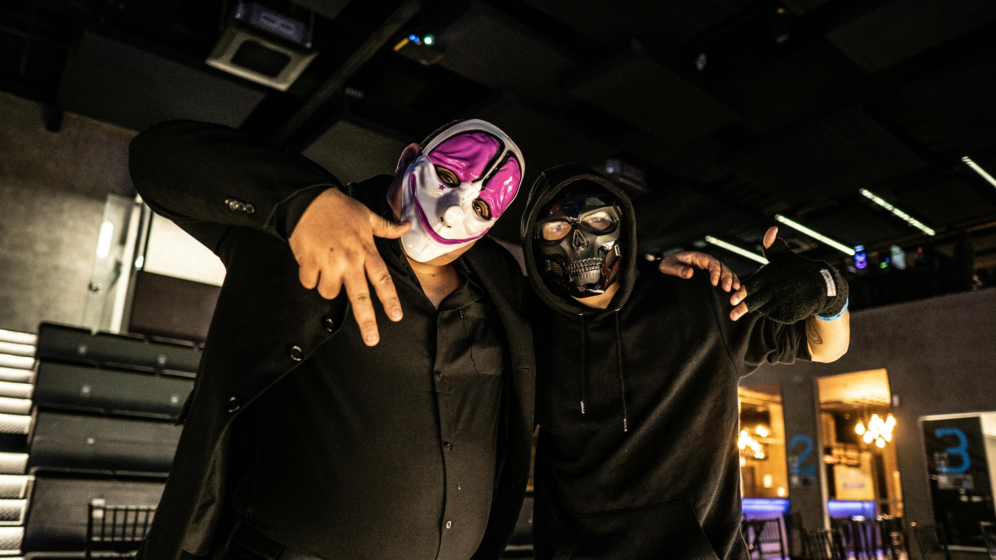 Two Men In Black Outfits With Scary Masks Embracing Each Other · Free ...