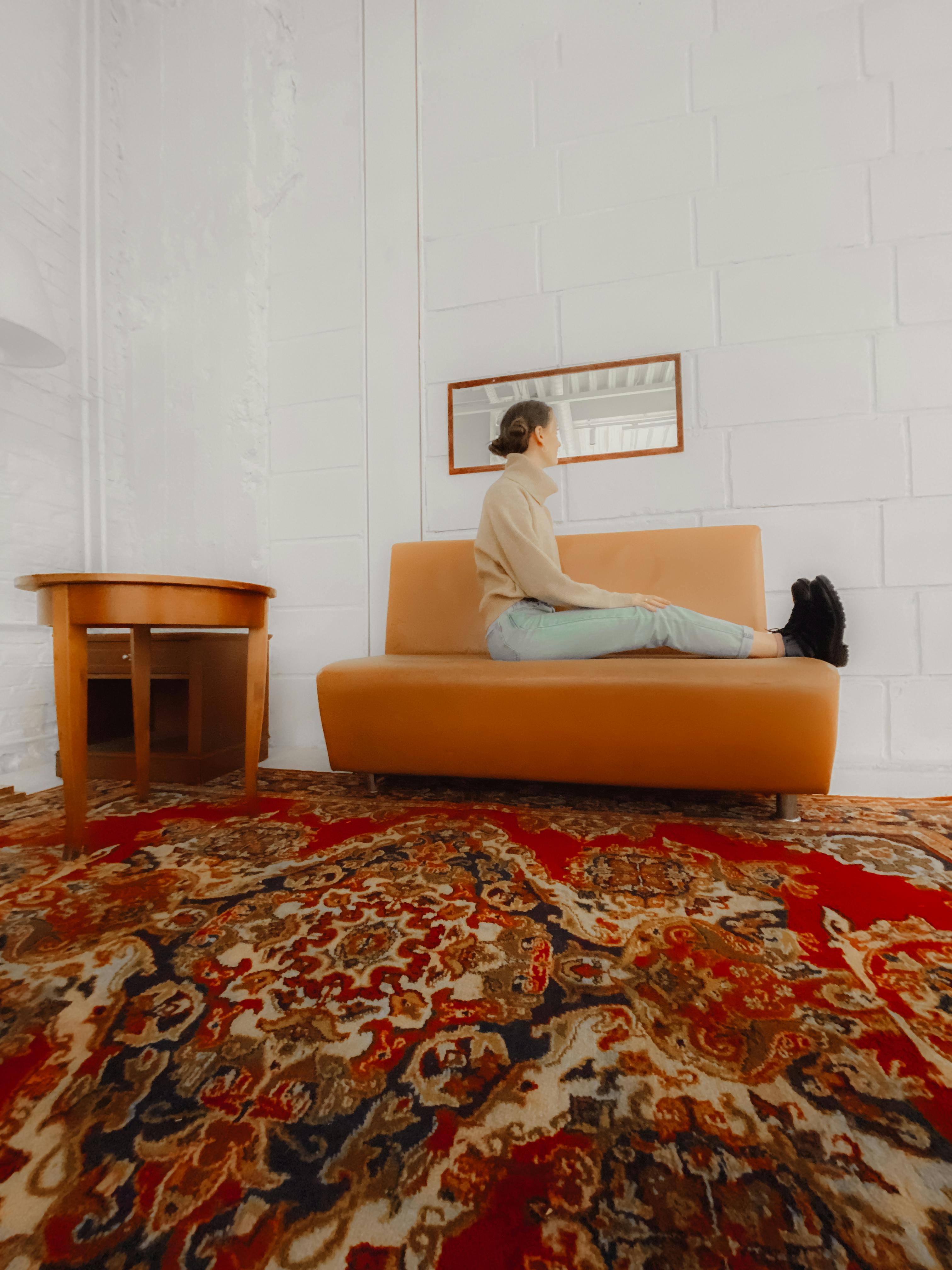 Woman sitting on leather couch in light room · Free Stock Photo