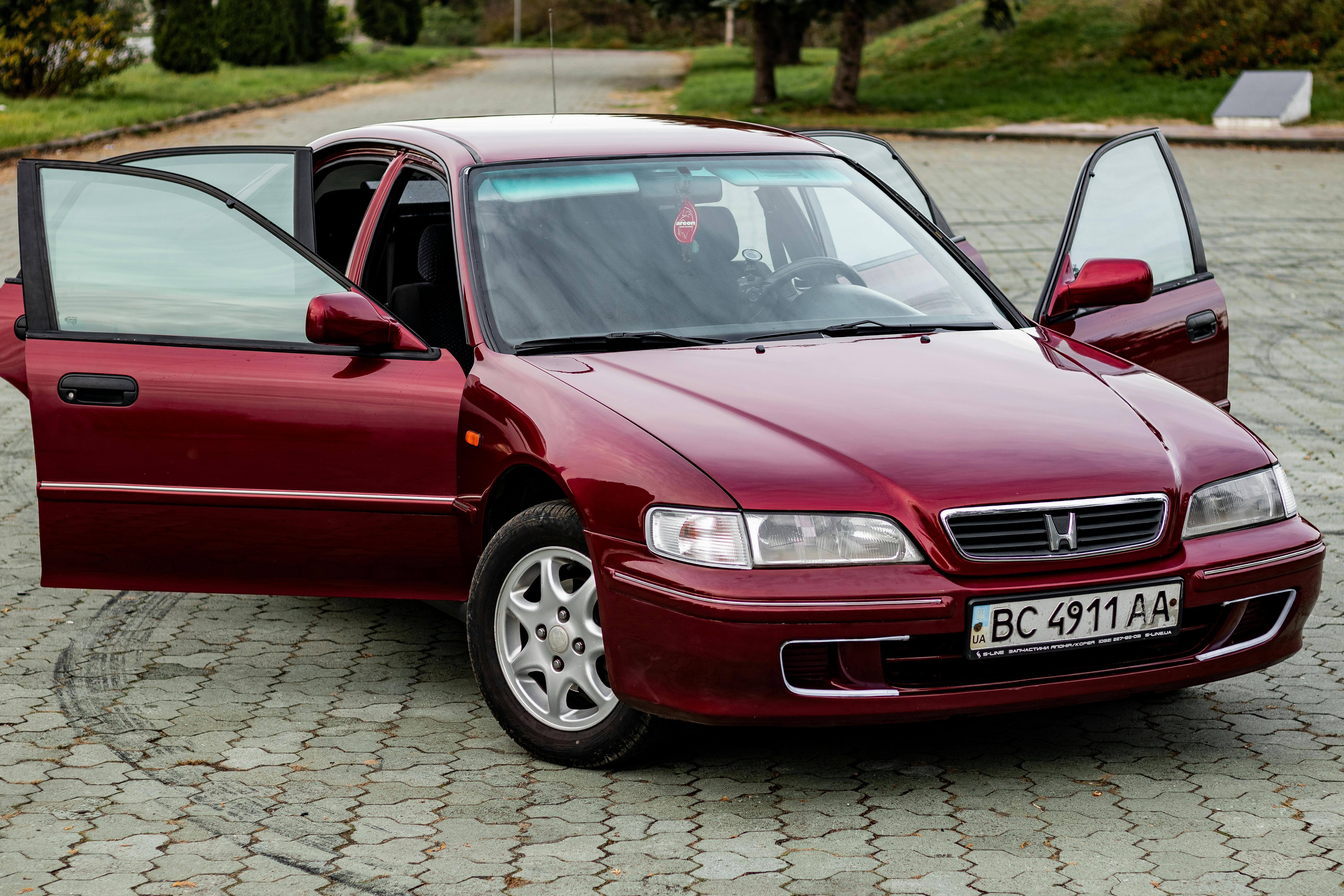 Red Sedan Car Parked on a Brick Pavement · Free Stock Photo