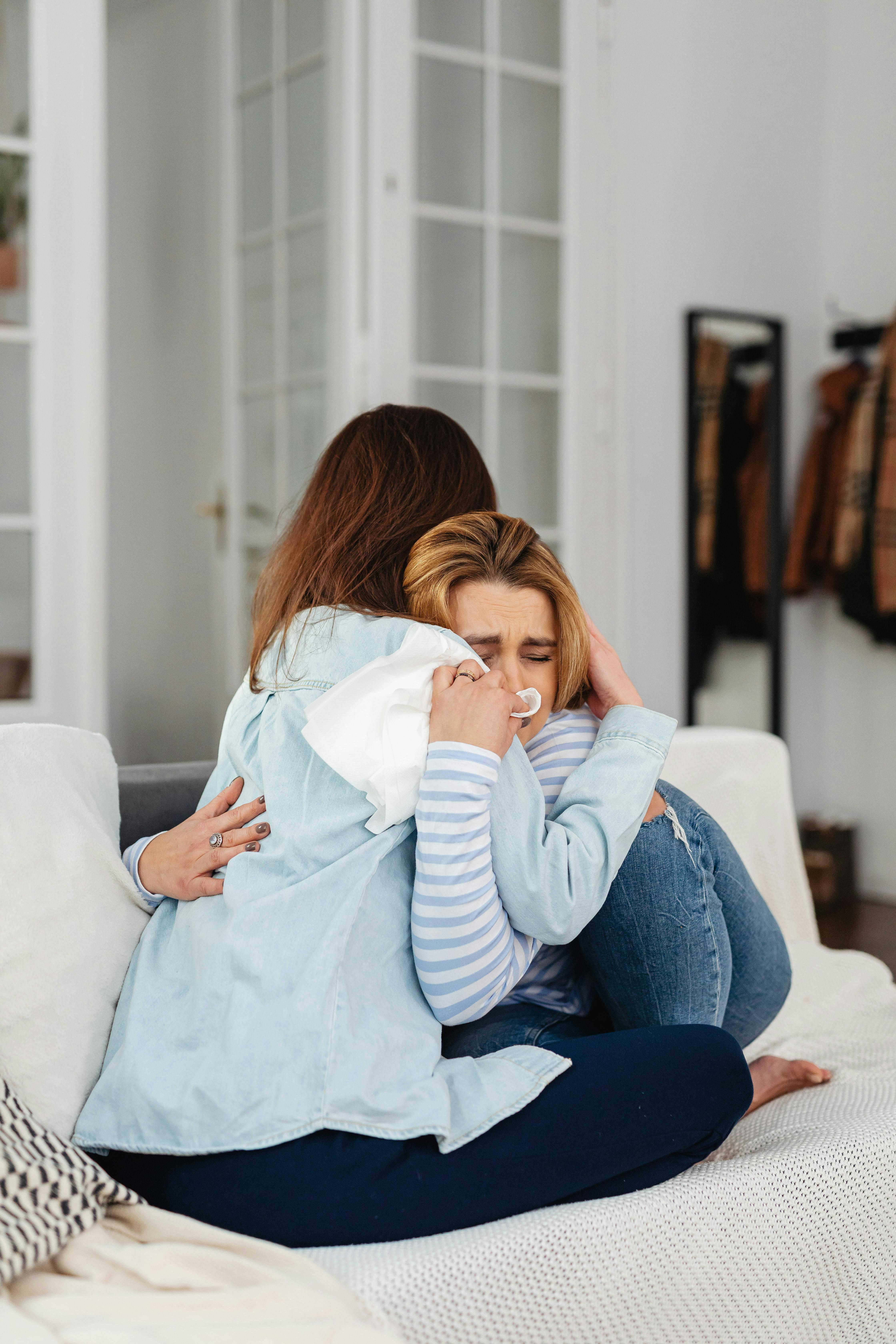 Sad Women Hugging on a Couch · Free Stock Photo