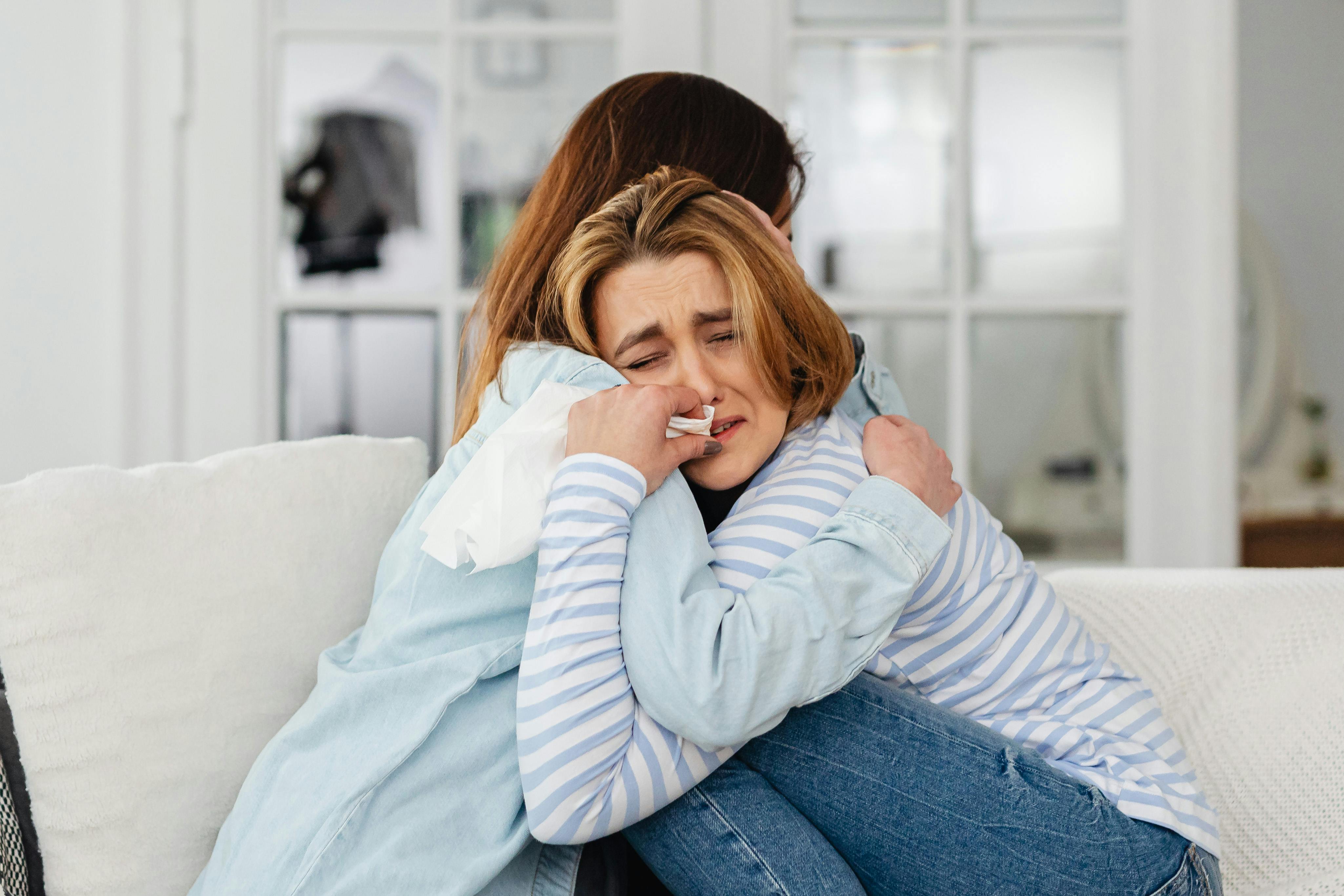 Sad Women Hugging on a Couch · Free Stock Photo