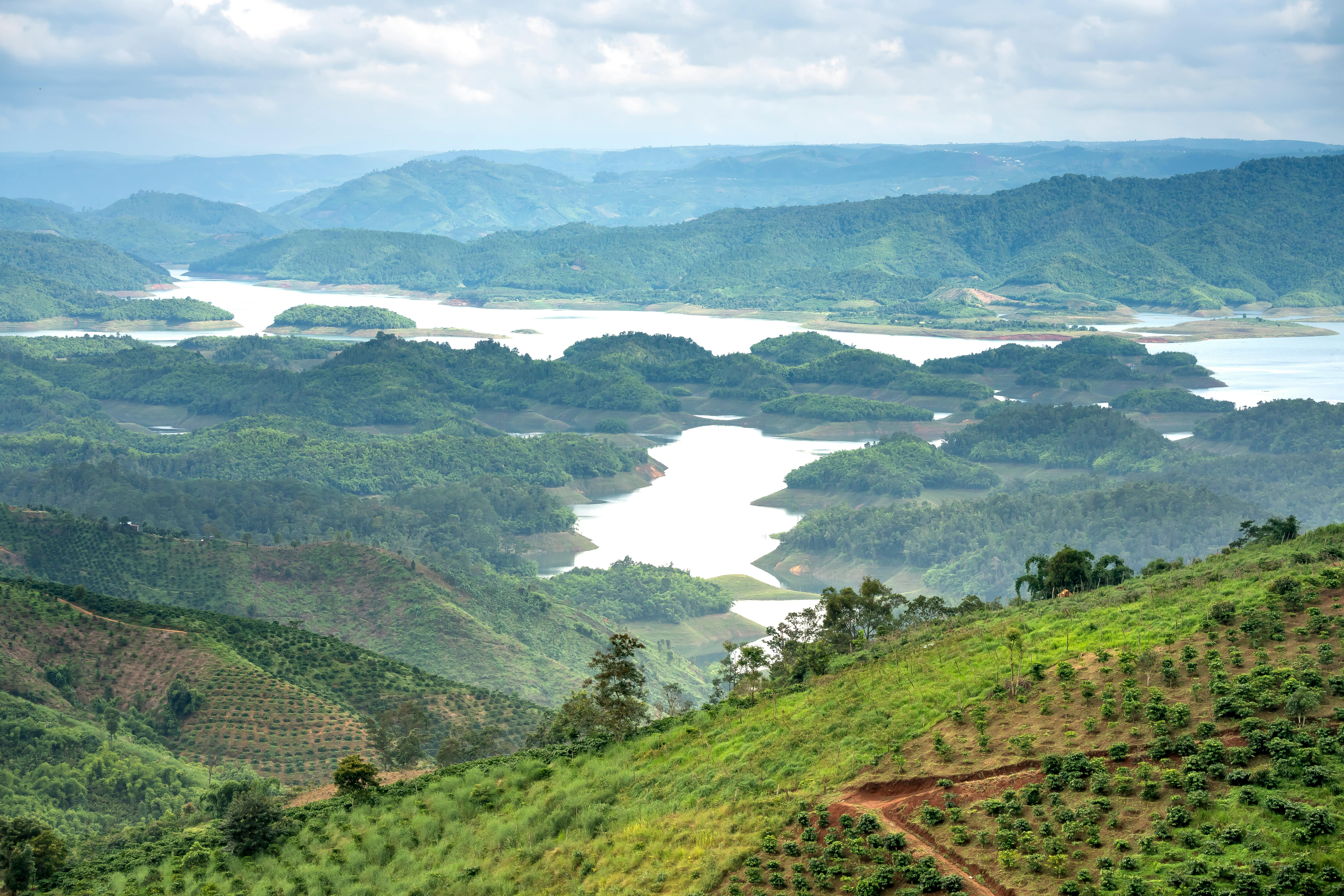 Hilly terrain with calm river · Free Stock Photo