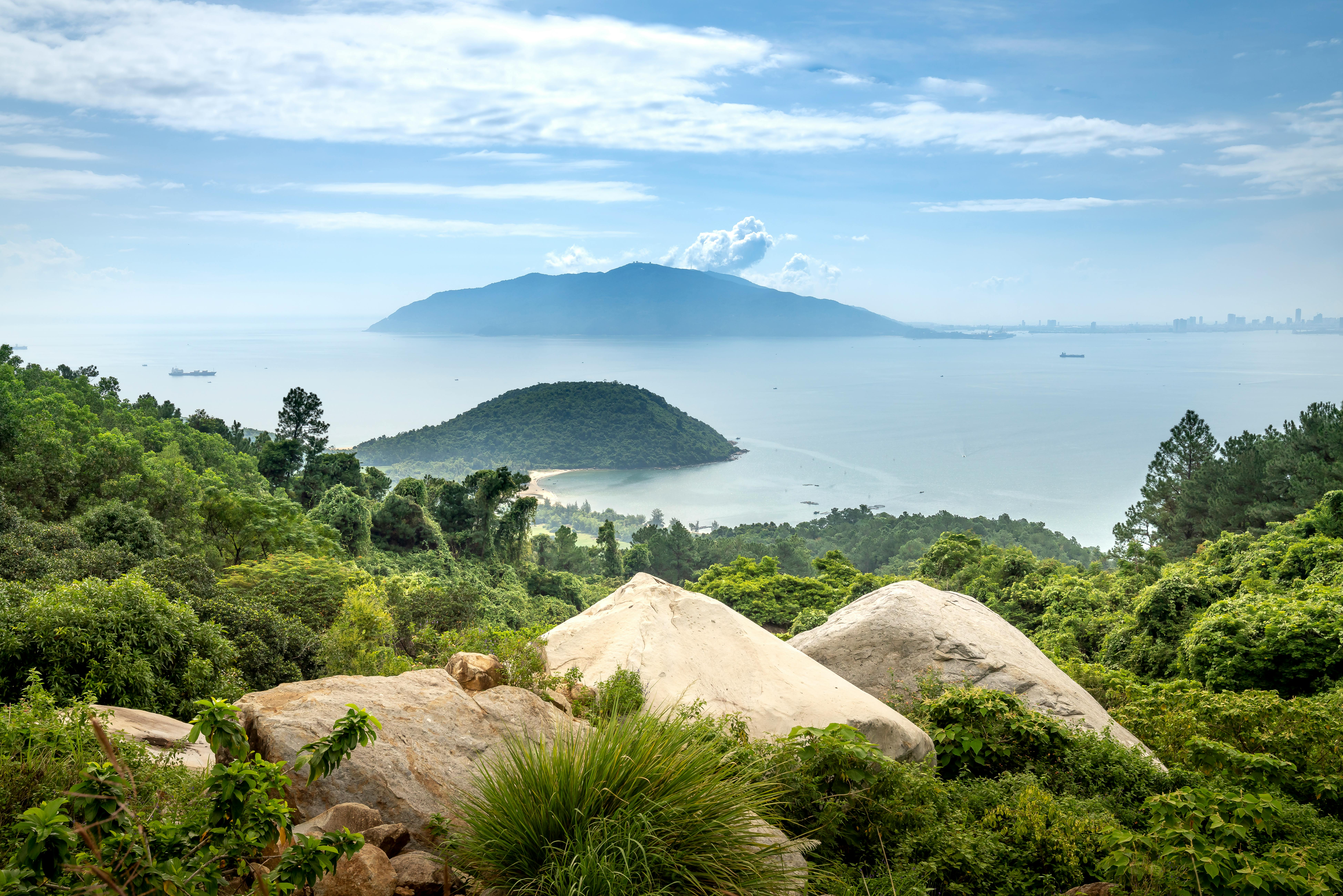 Rocks on grassy hill against sea · Free Stock Photo