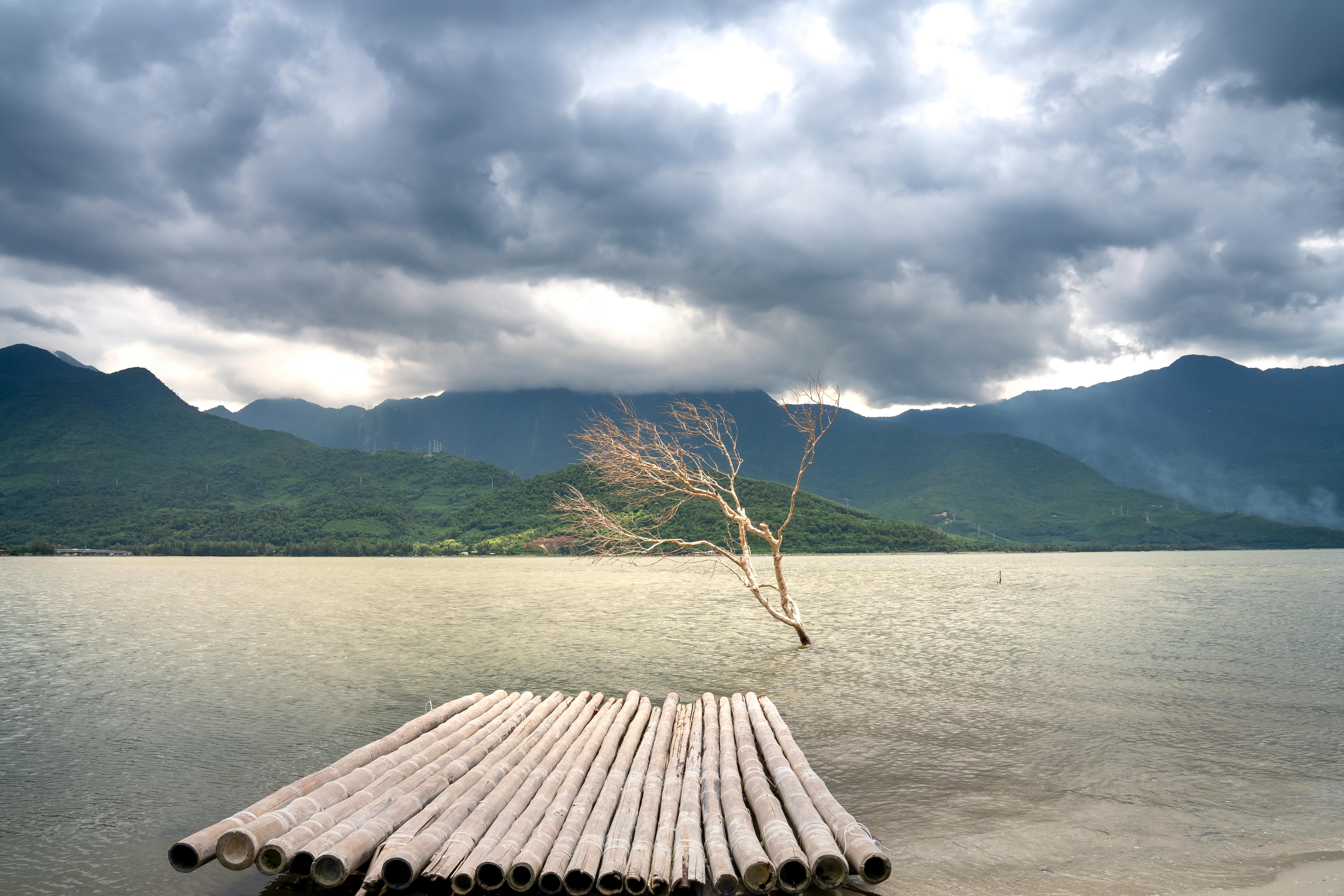 Wooden raft on rippling river in scenic hilly terrain · Free Stock Photo