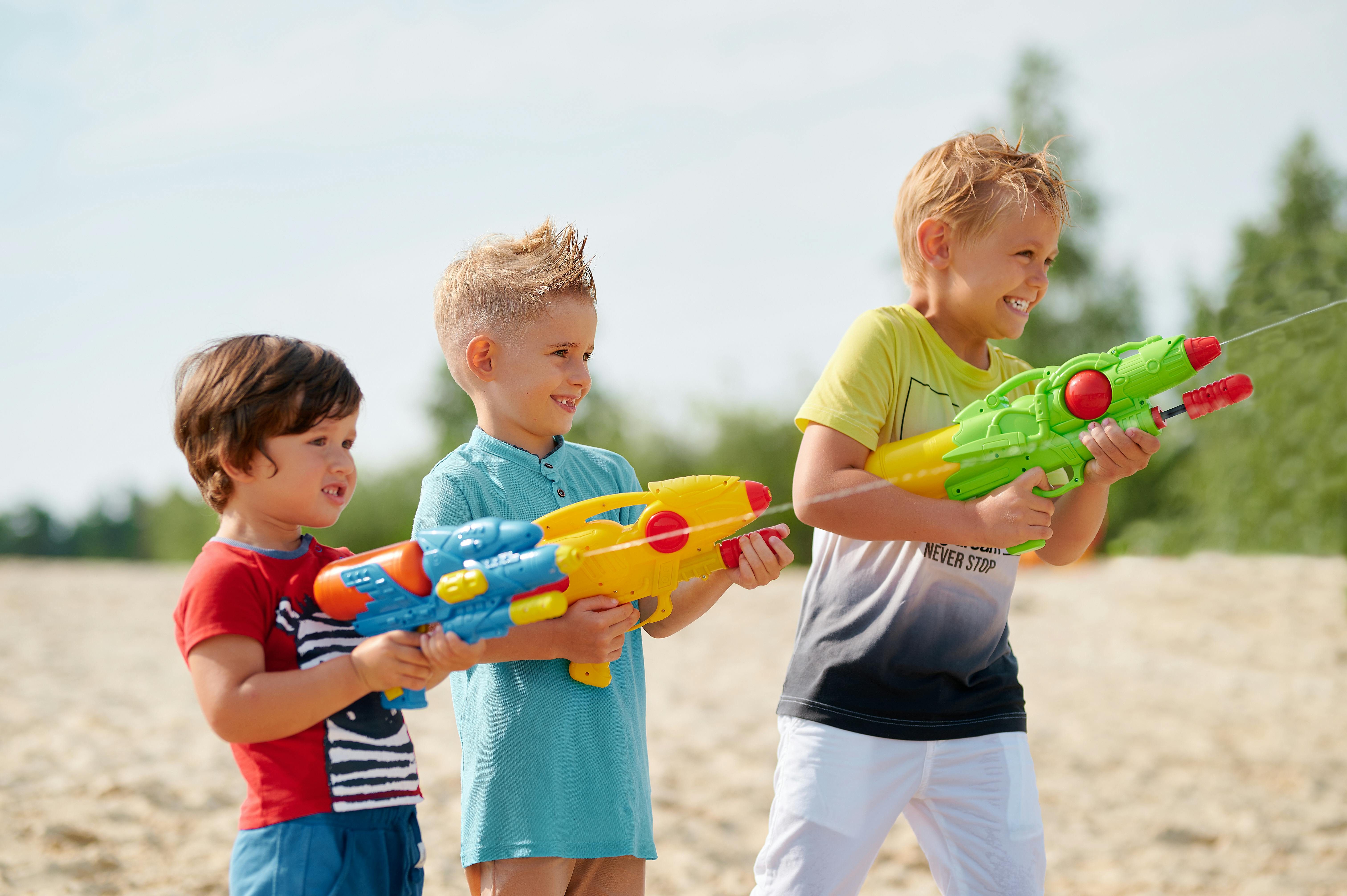 Kids Playing Water Gun on the Shore Free Stock Photo