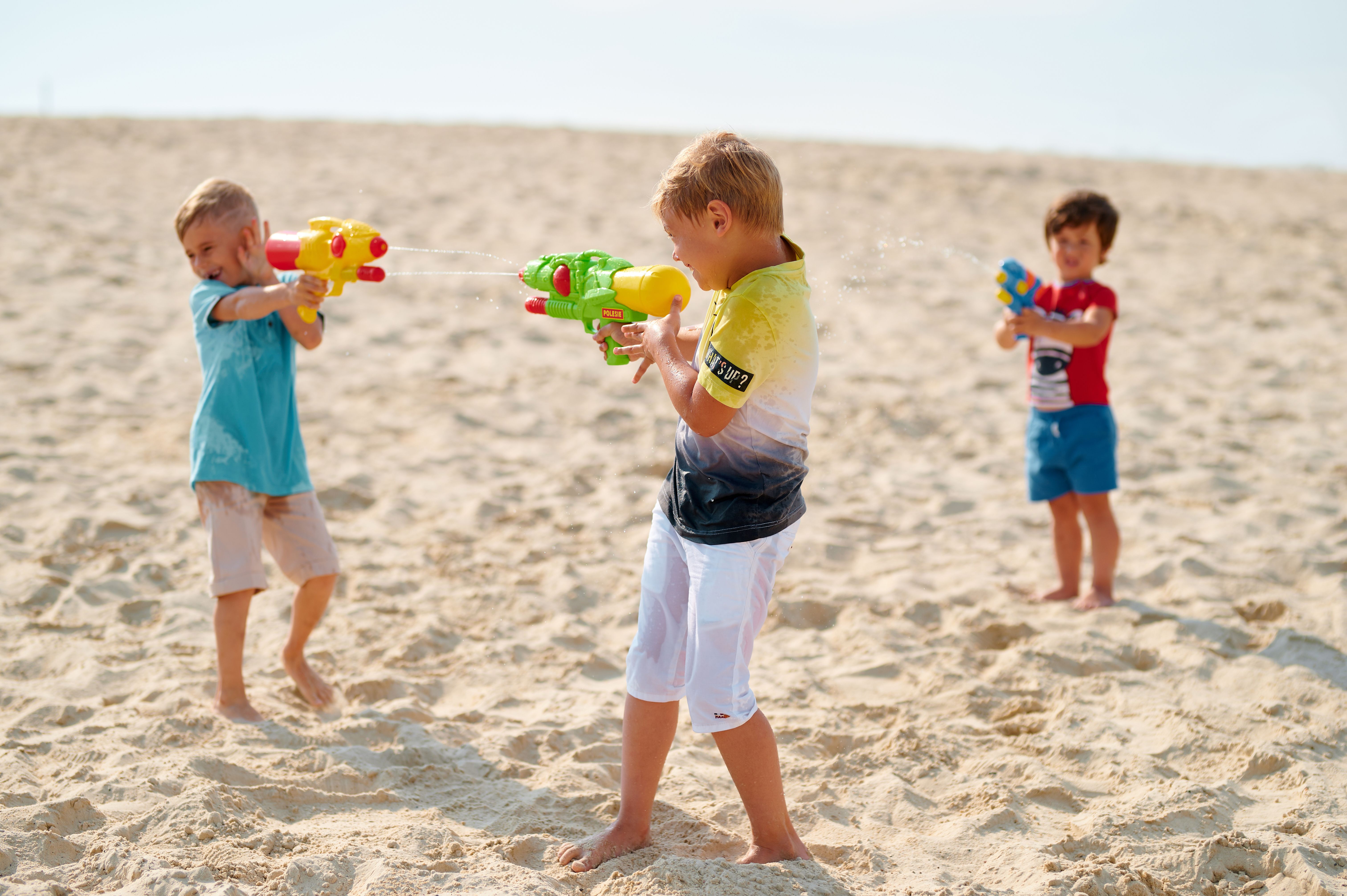 Children Playing Water Guns on the Sand · Free Stock Photo