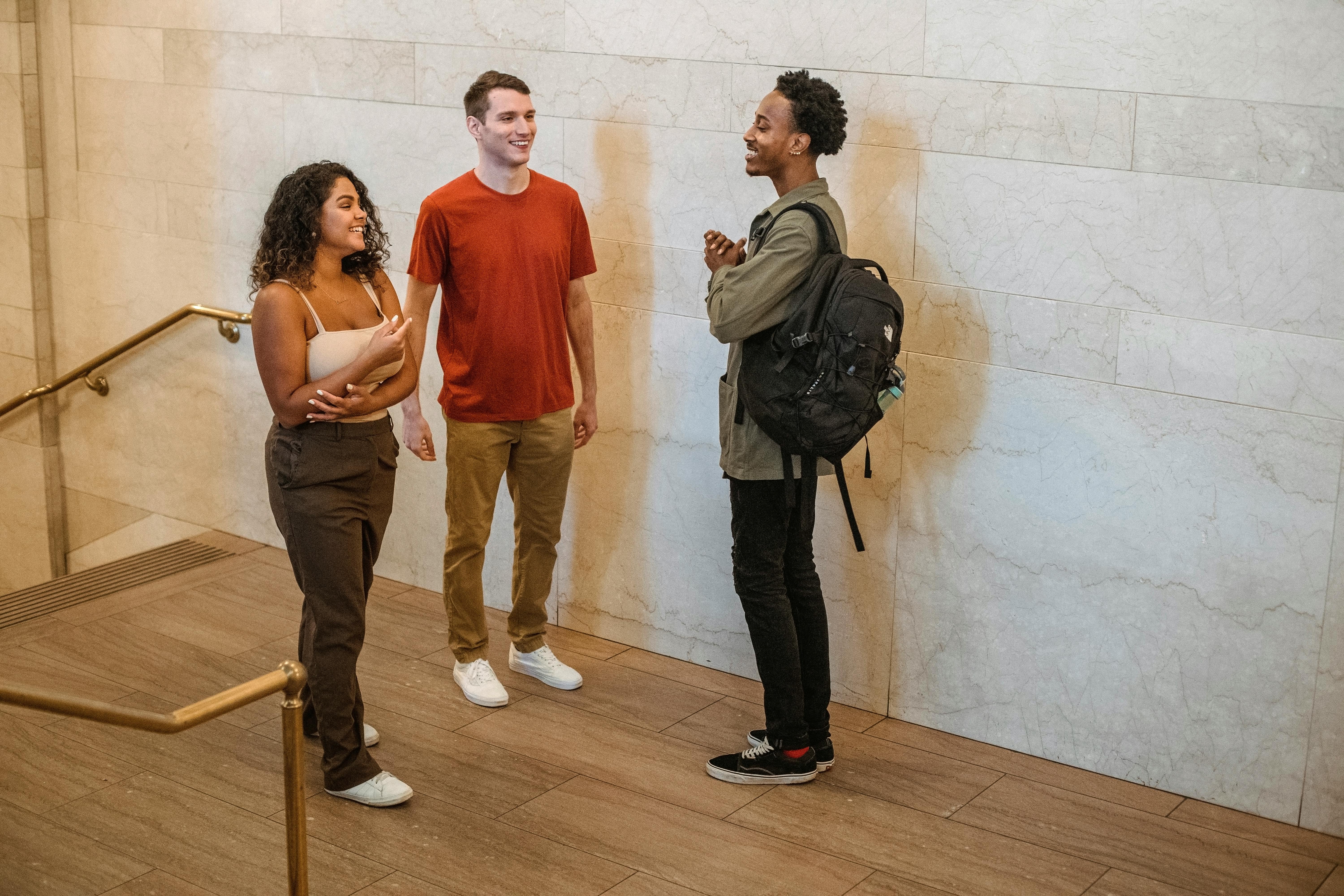 Diverse friends speaking in hallway · Free Stock Photo