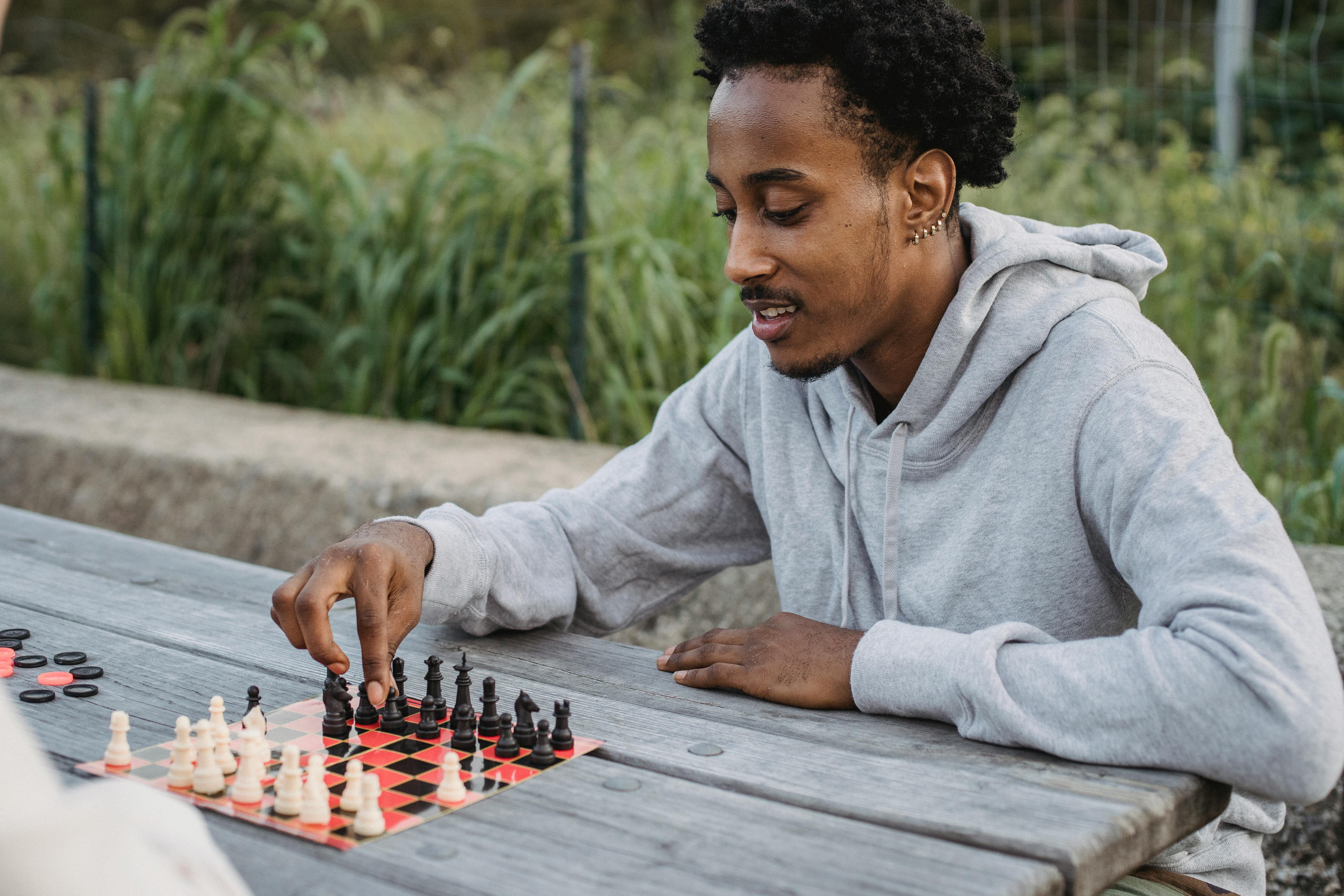 Focused black man making chess move · Free Stock Photo