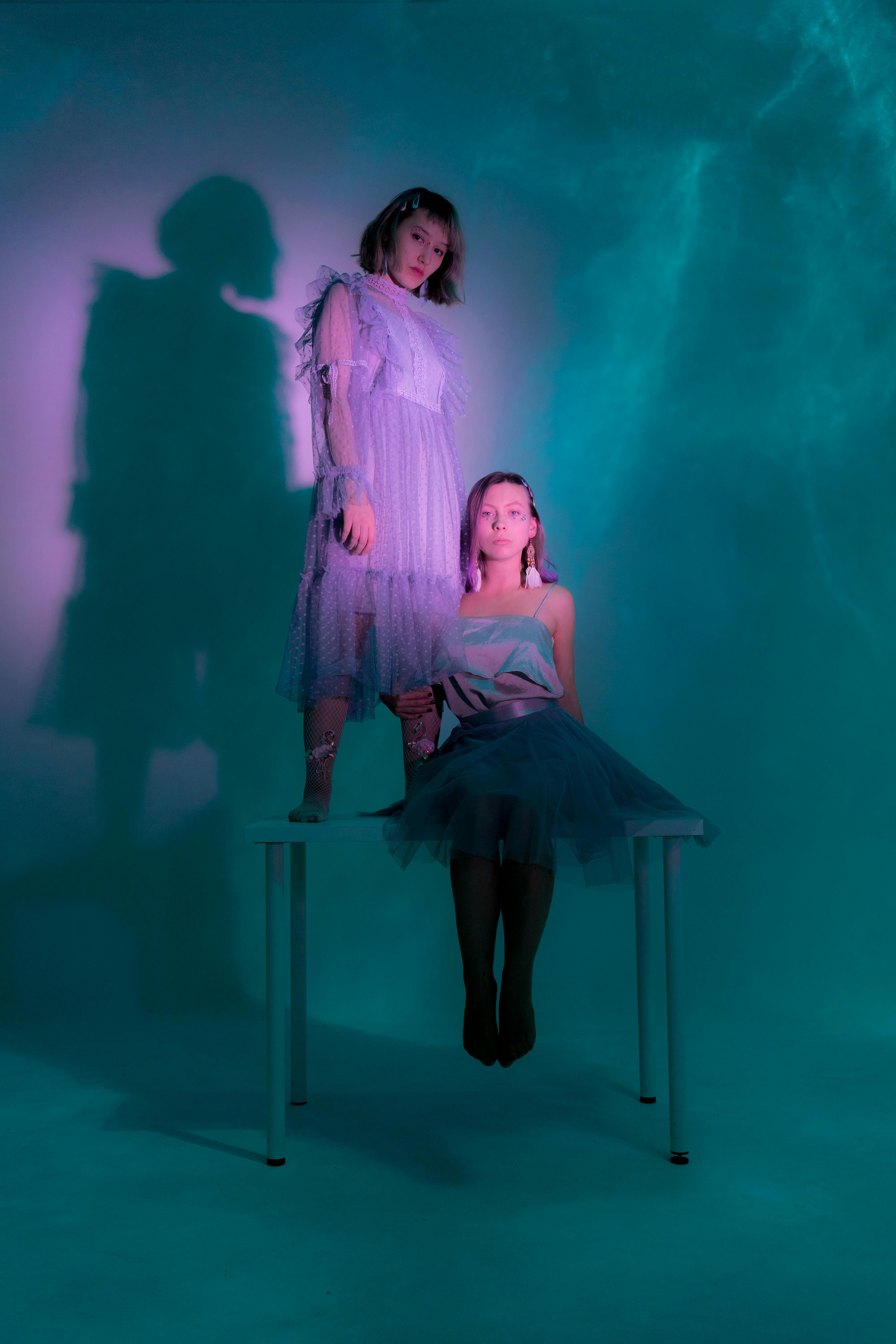 Stylish women on table in studio · Free Stock Photo