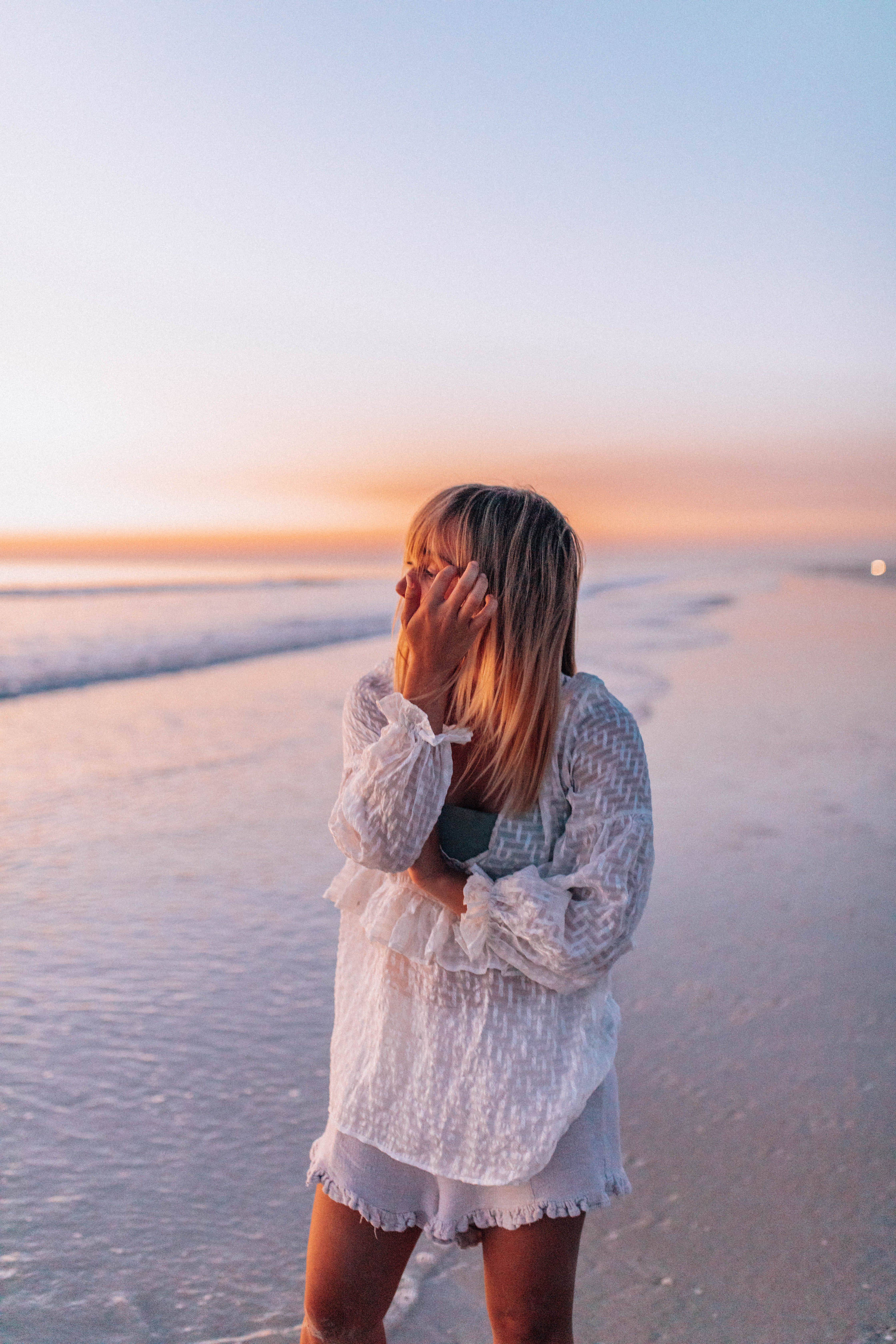 Woman Standing on a Beach at Sunset · Free Stock Photo