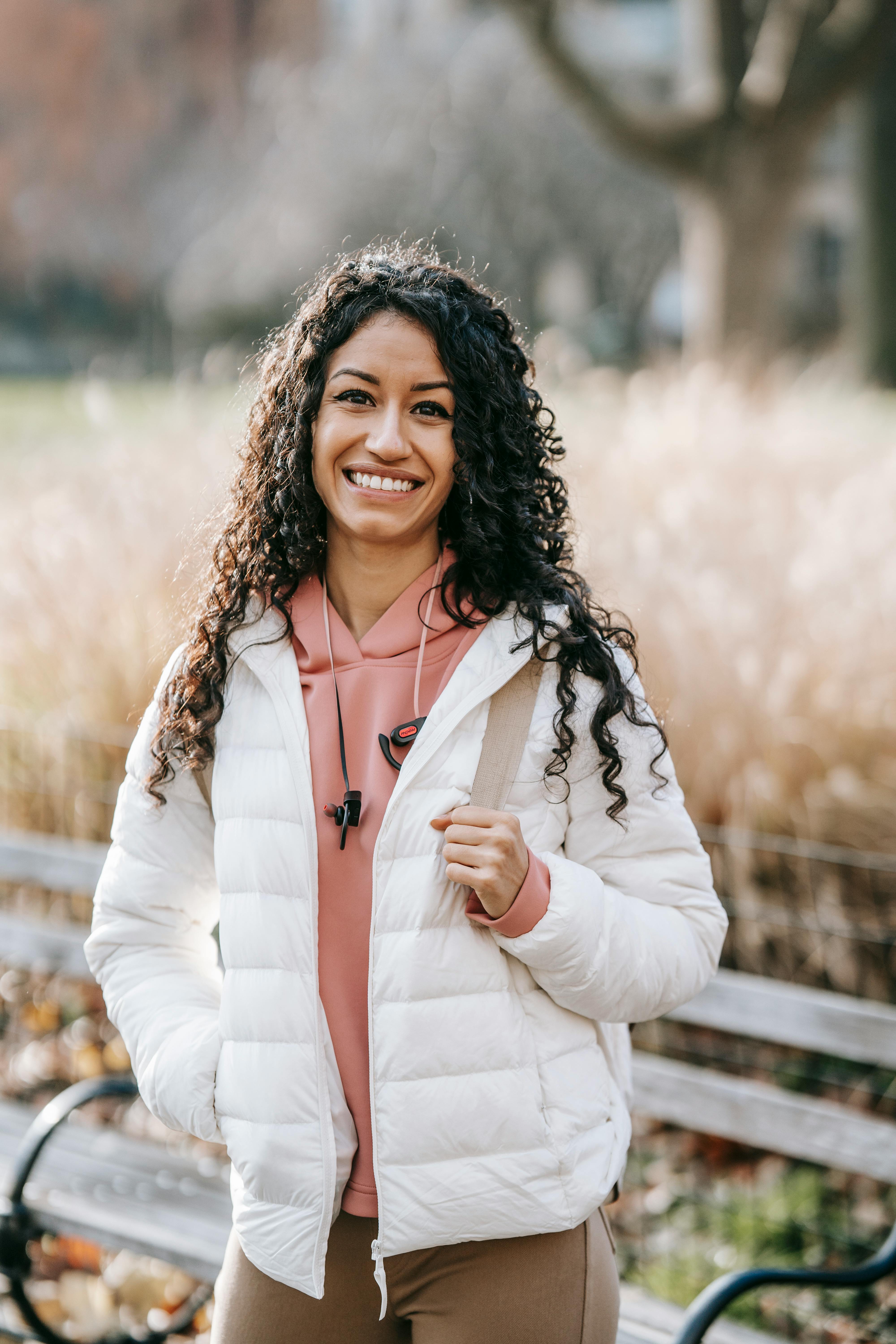 Happy Hispanic woman standing in park · Free Stock Photo