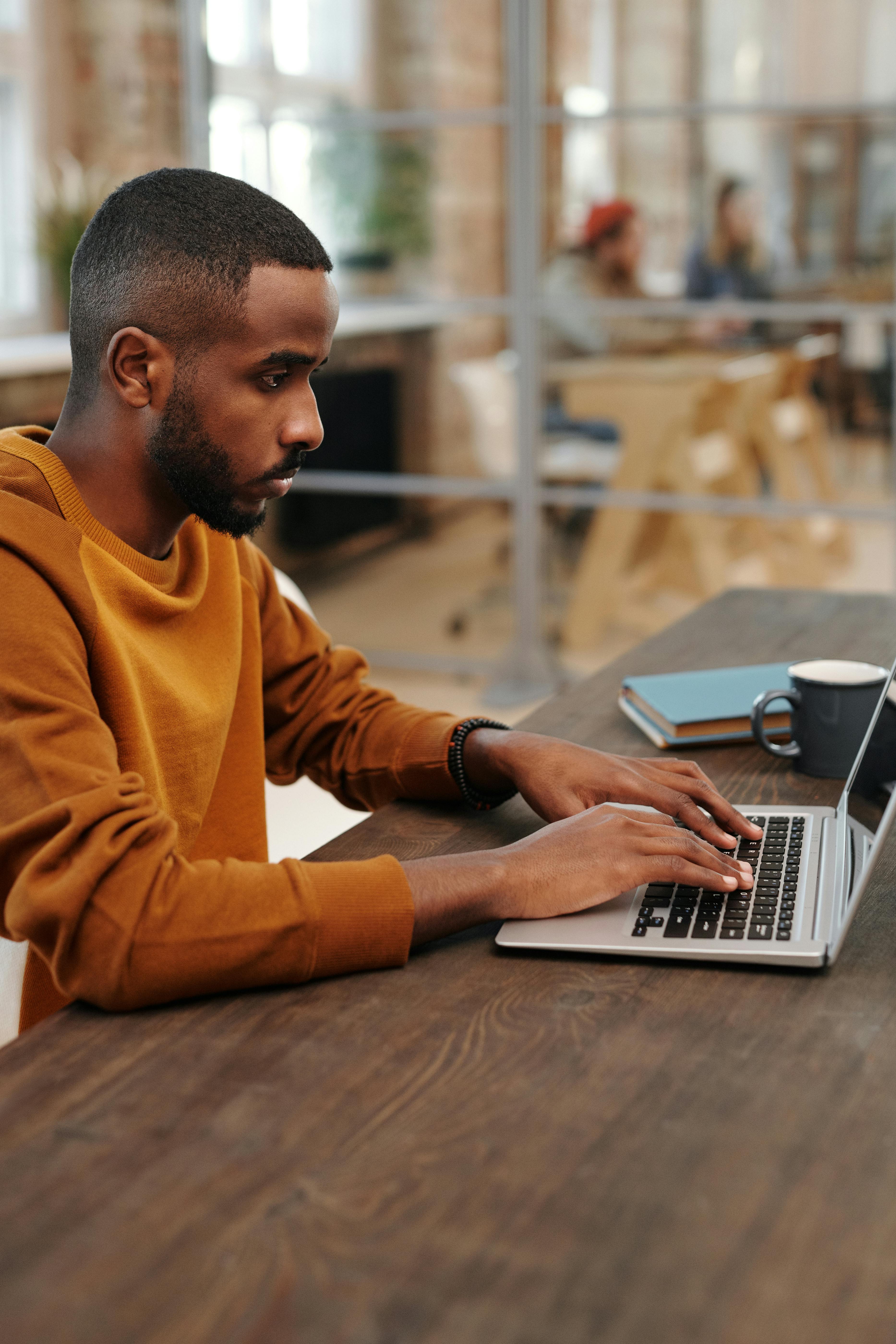 A Sitting Man Using a Laptop · Free Stock Photo