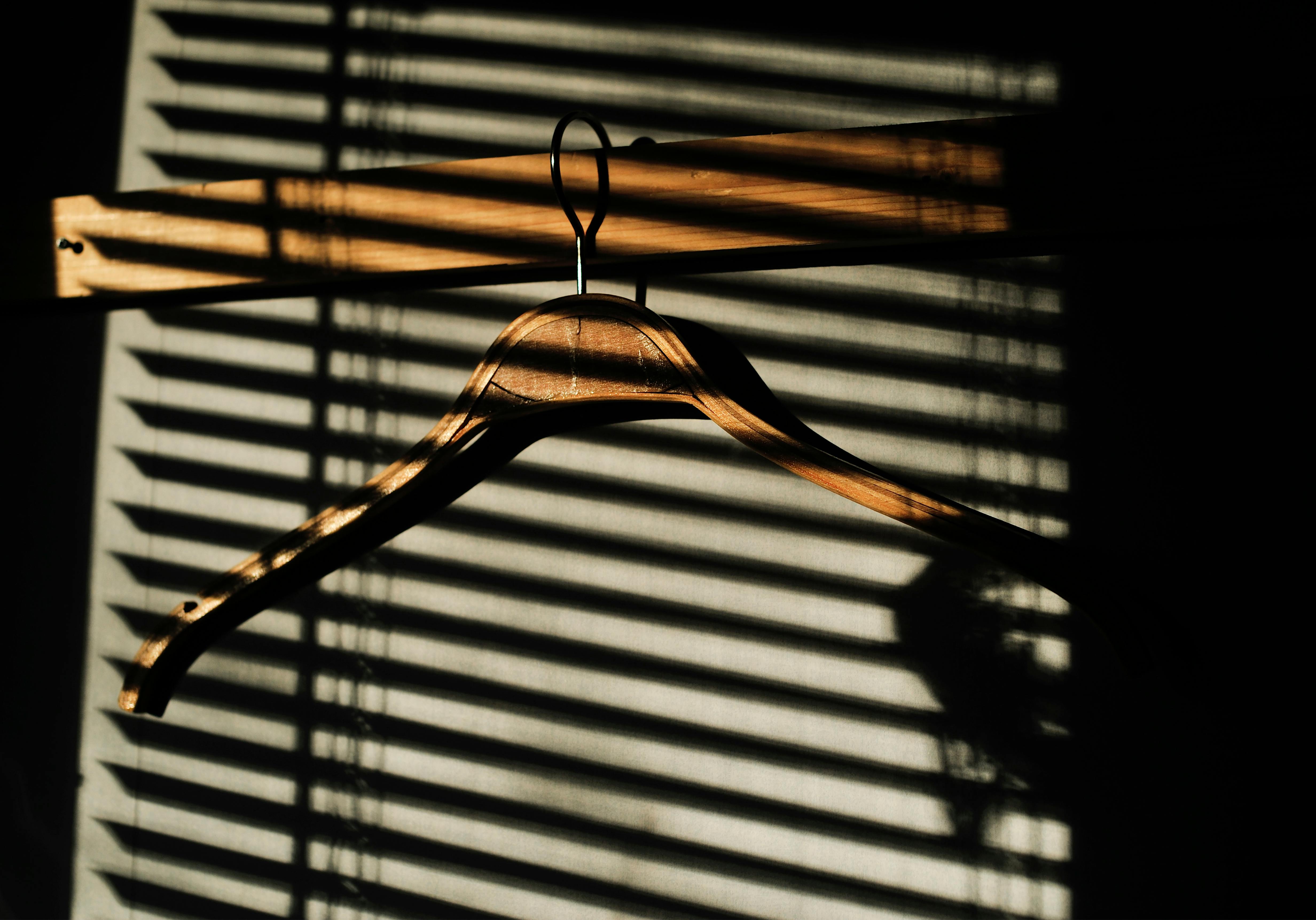 A Wooden Hanger Hanging on a Rack · Free Stock Photo