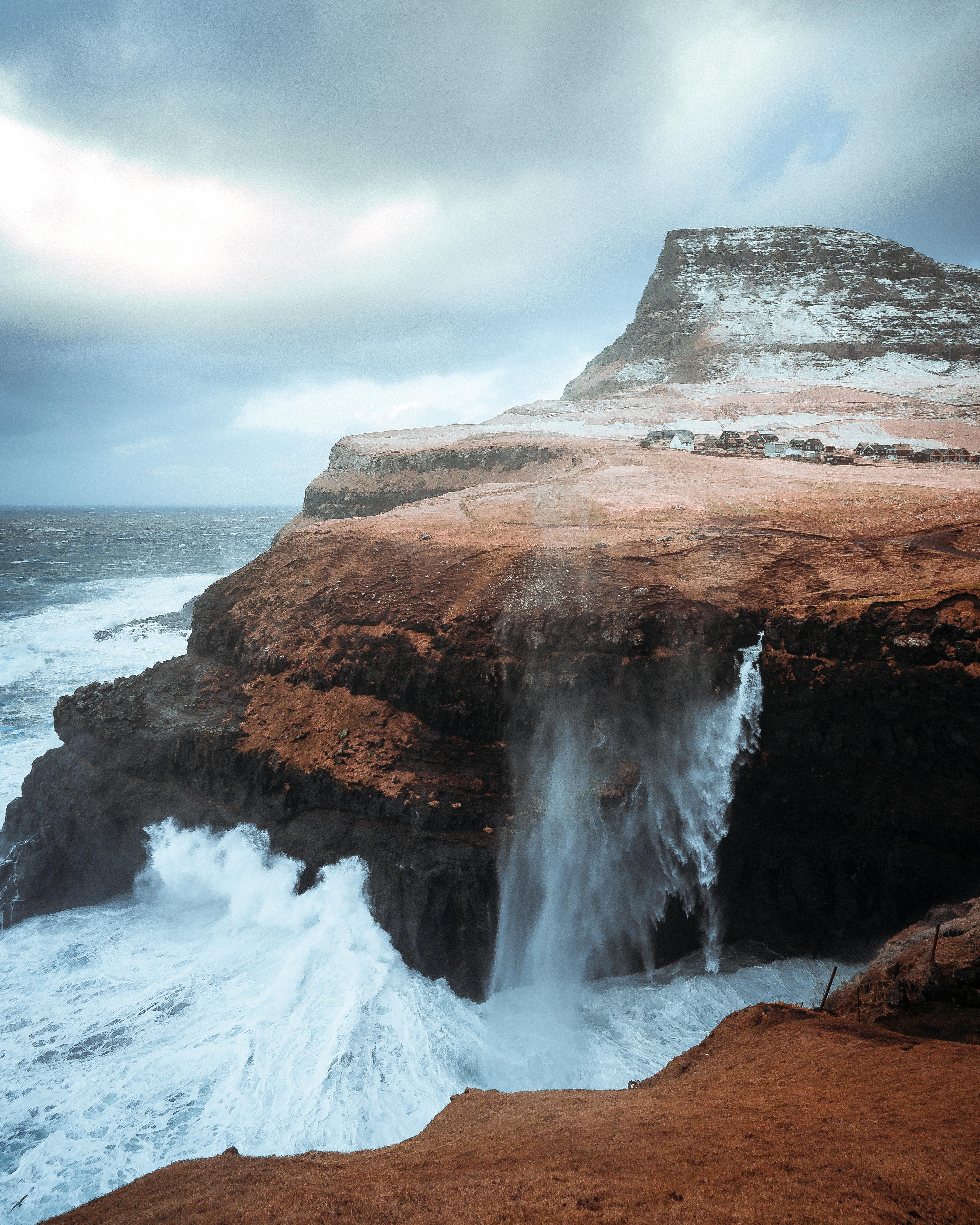 Stormy sea with rocky cliffs in daylight · Free Stock Photo