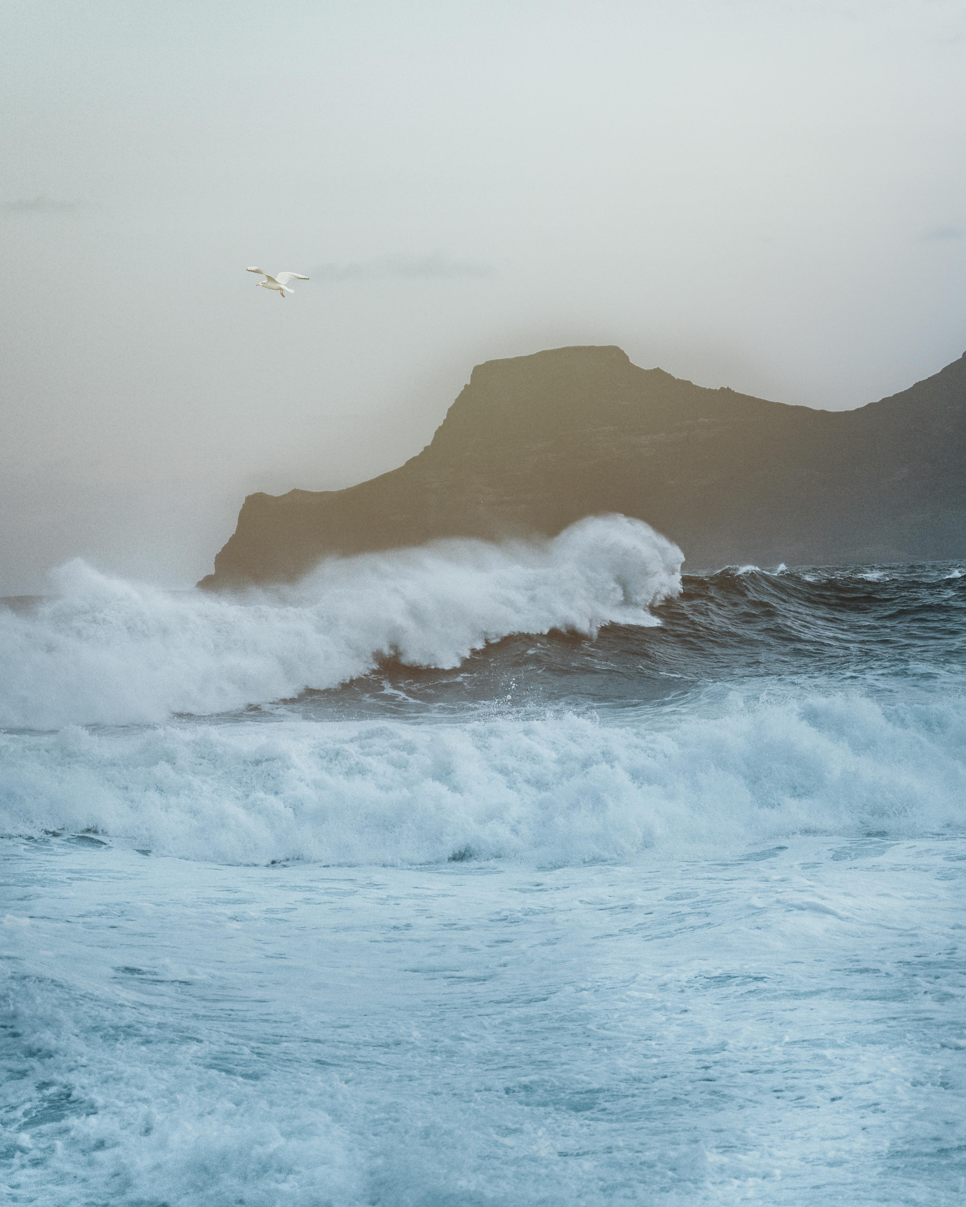 Stormy sea waving near rocky cliff · Free Stock Photo