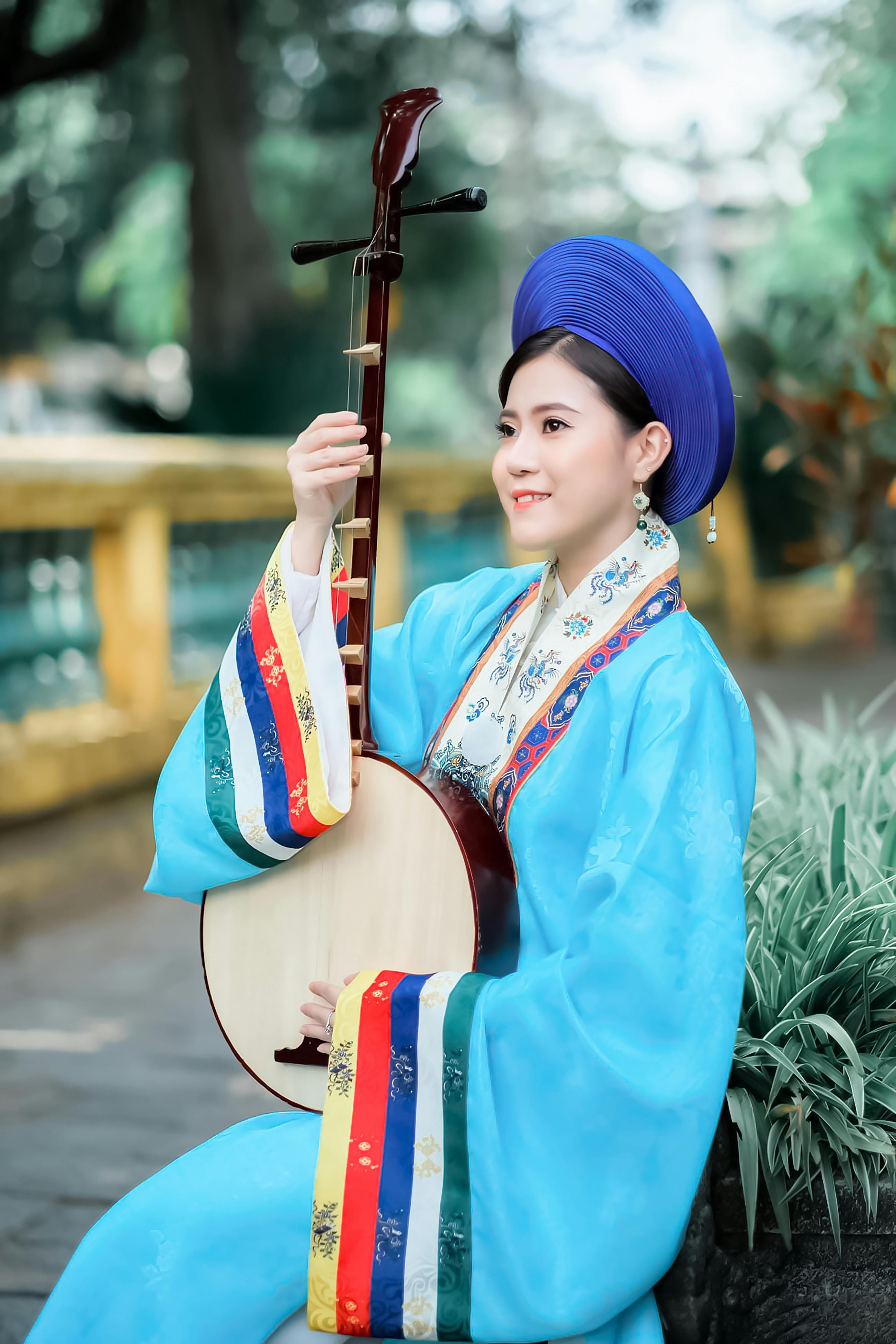Elegant Lady playing a Traditional Stringed Instrument · Free Stock Photo