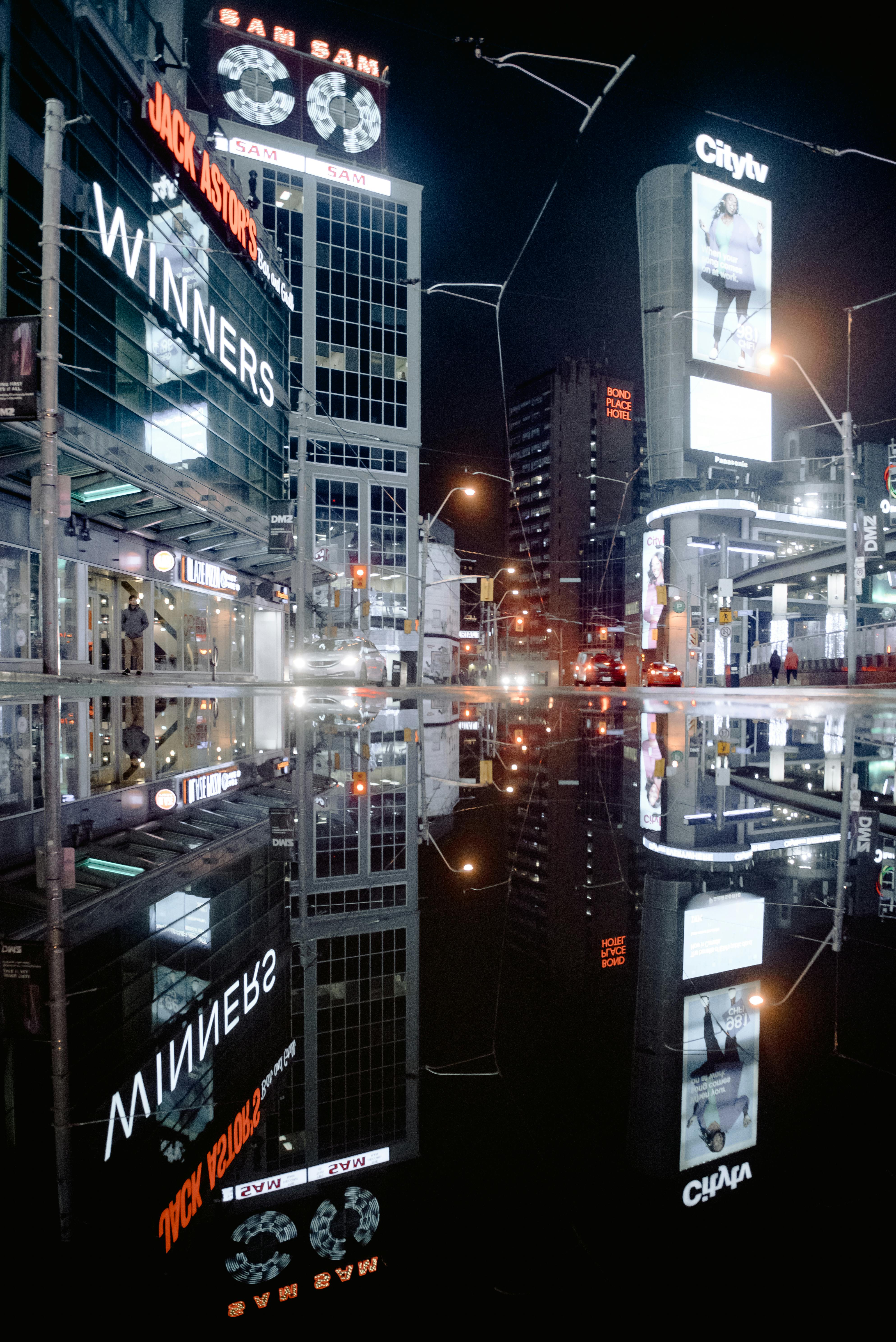 City street with cars and buildings at night · Free Stock Photo
