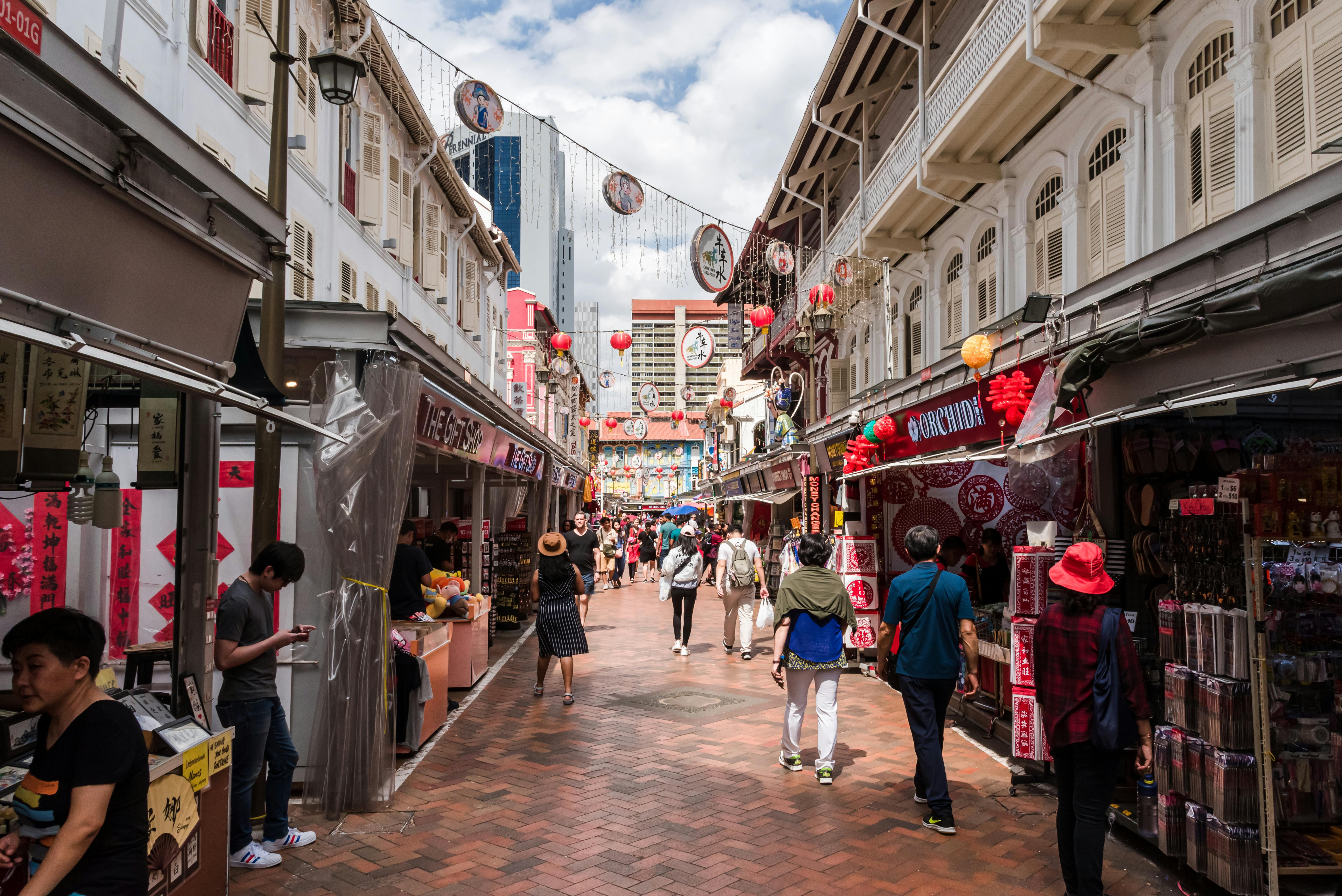 People Walking on a Street with Stores · Free Stock Photo