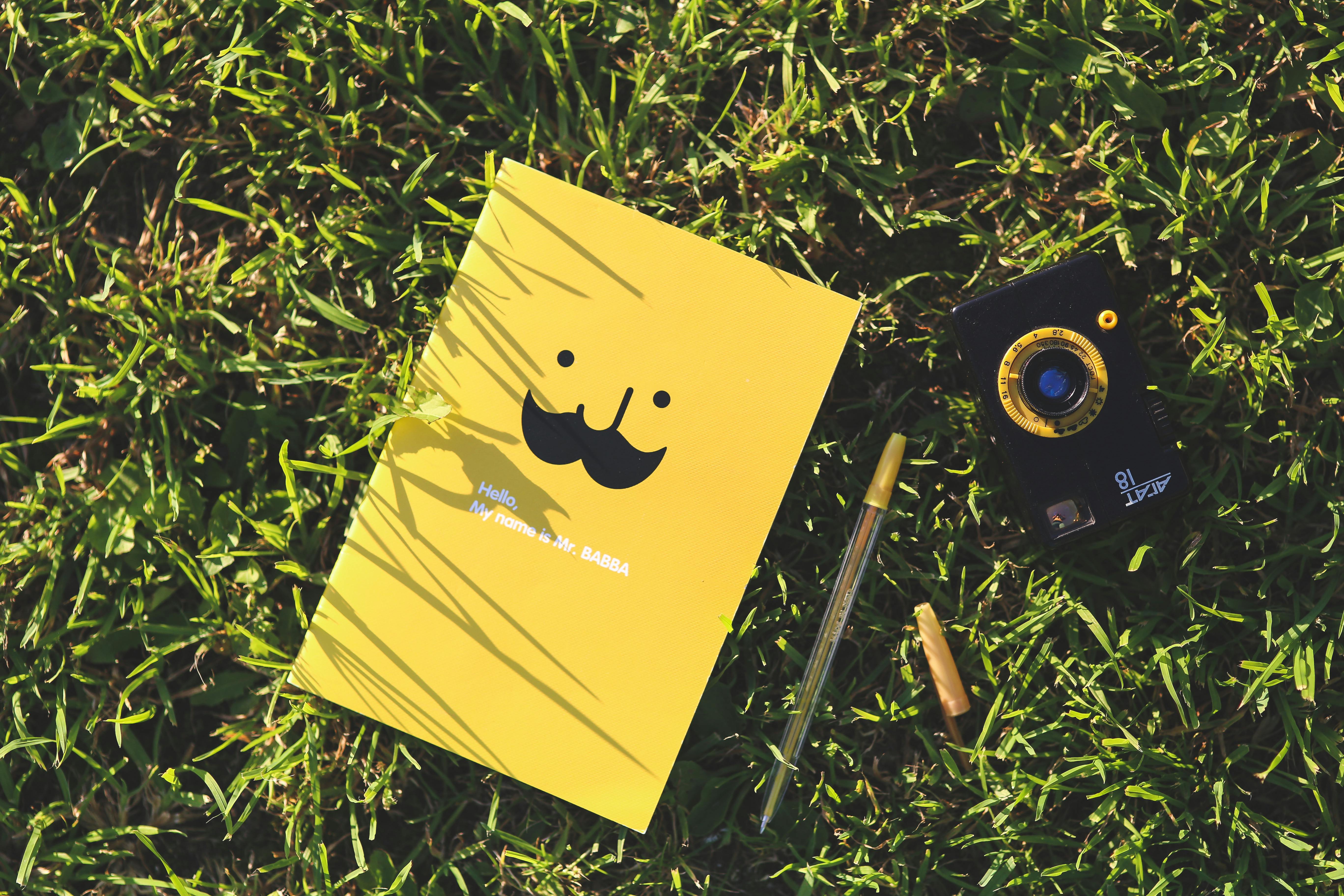 Yellow notebook on the grass · Free Stock Photo