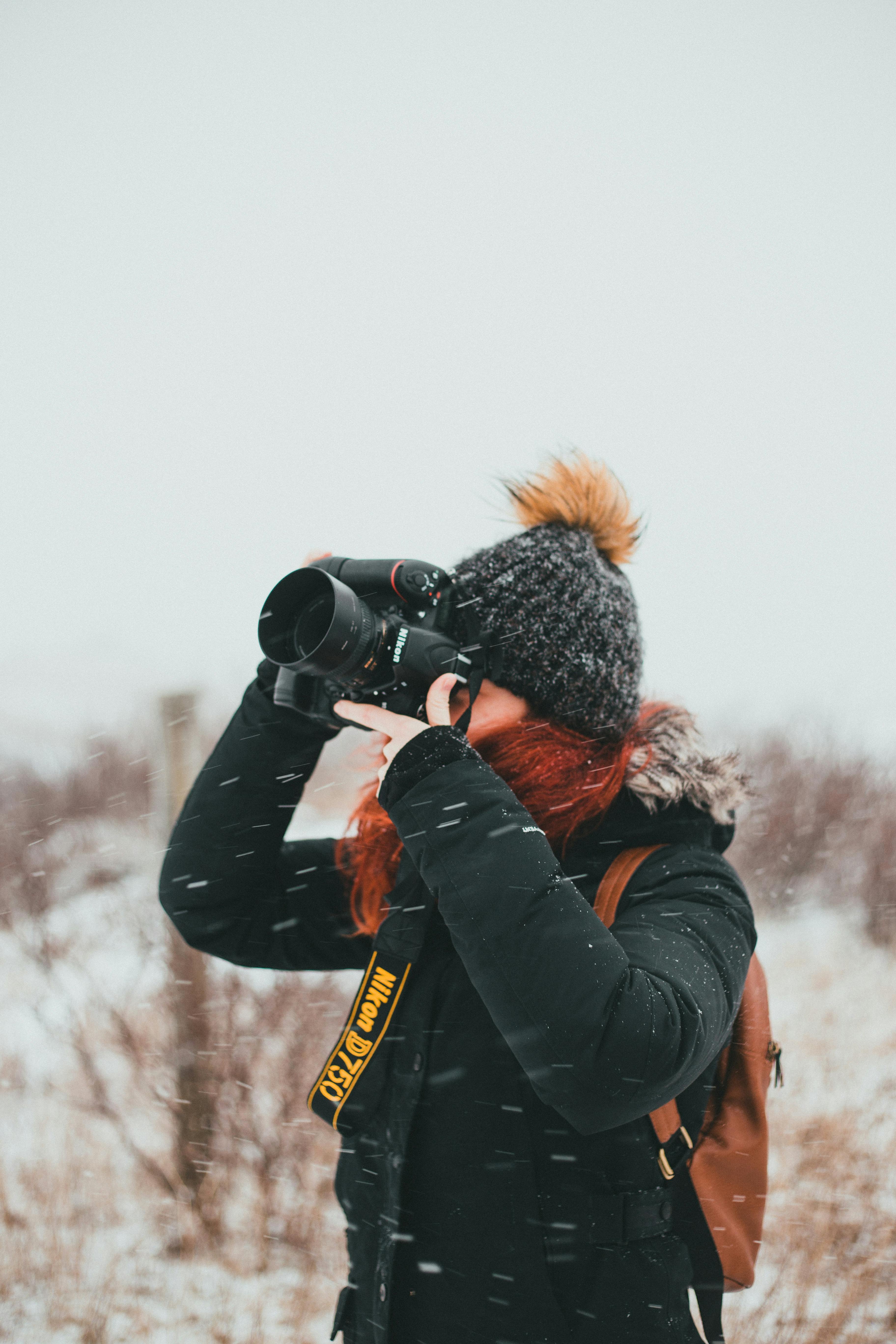 Anonymous photographer shooting sea on sandy shore · Free Stock Photo