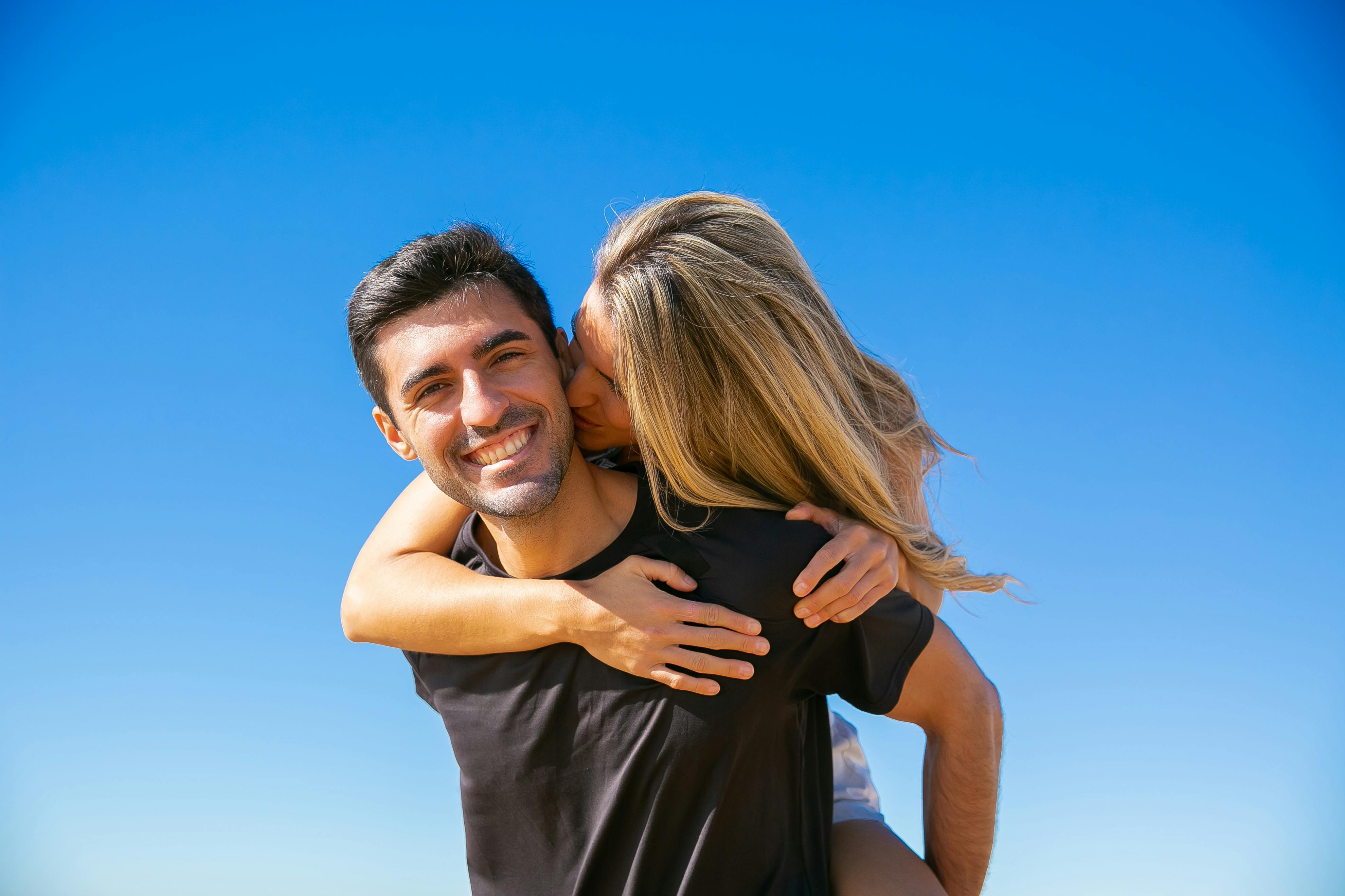 A Man Carrying a Person Smiling · Free Stock Photo