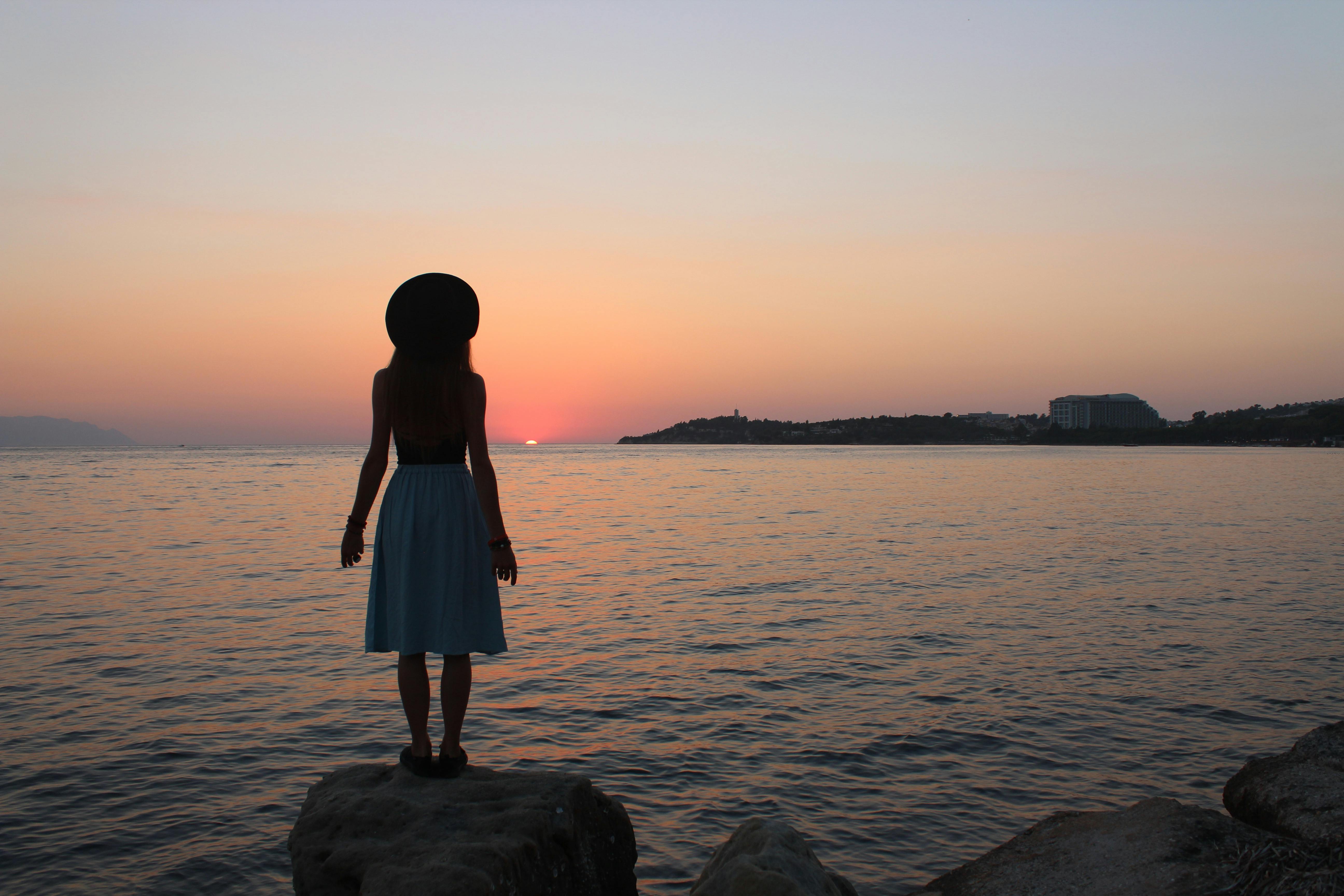Woman Standing on Beach during Sunset · Free Stock Photo