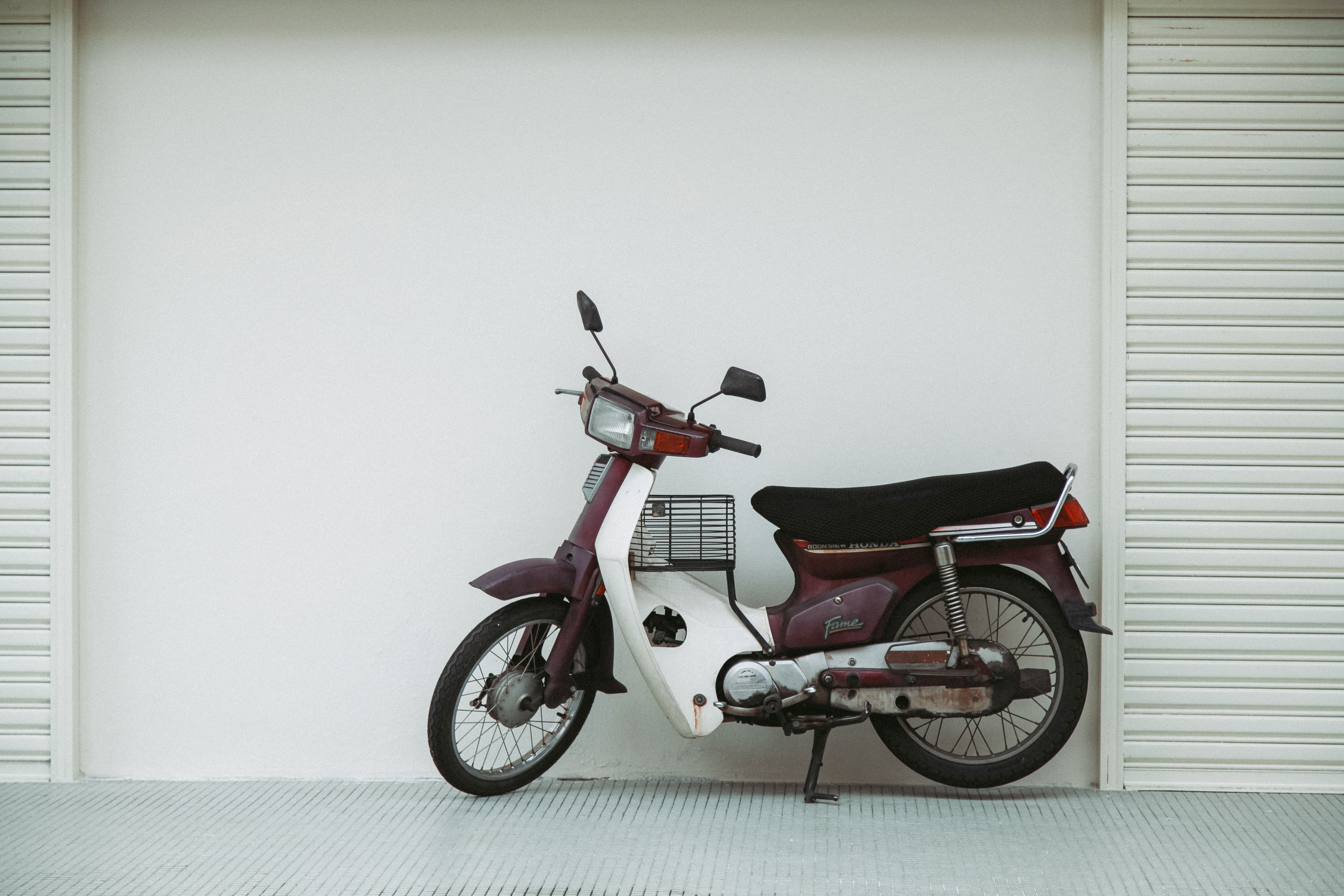 Motorcycle parked near white wall · Free Stock Photo