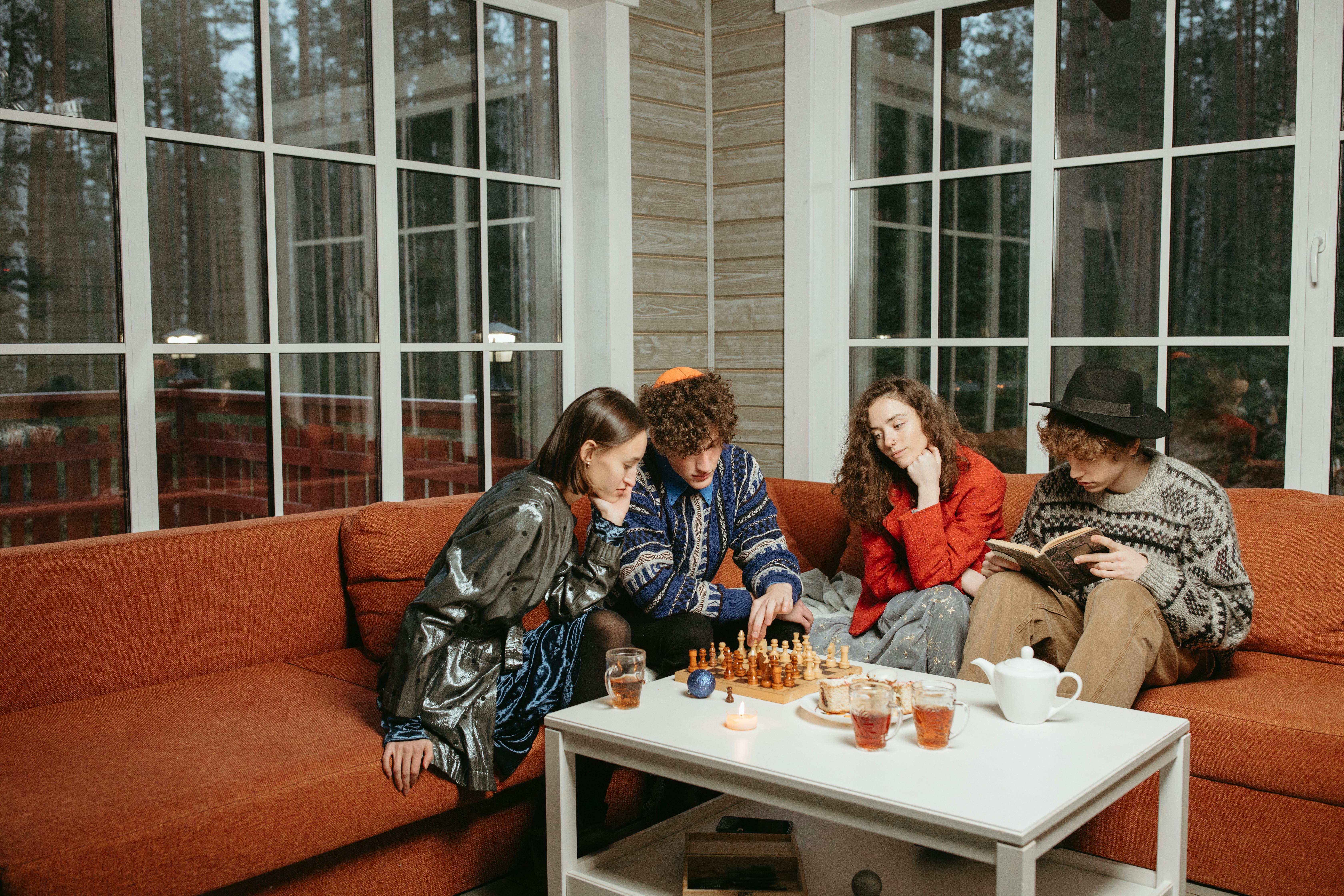 Friends Playing Chess while Sitting on a Couch · Free Stock Photo