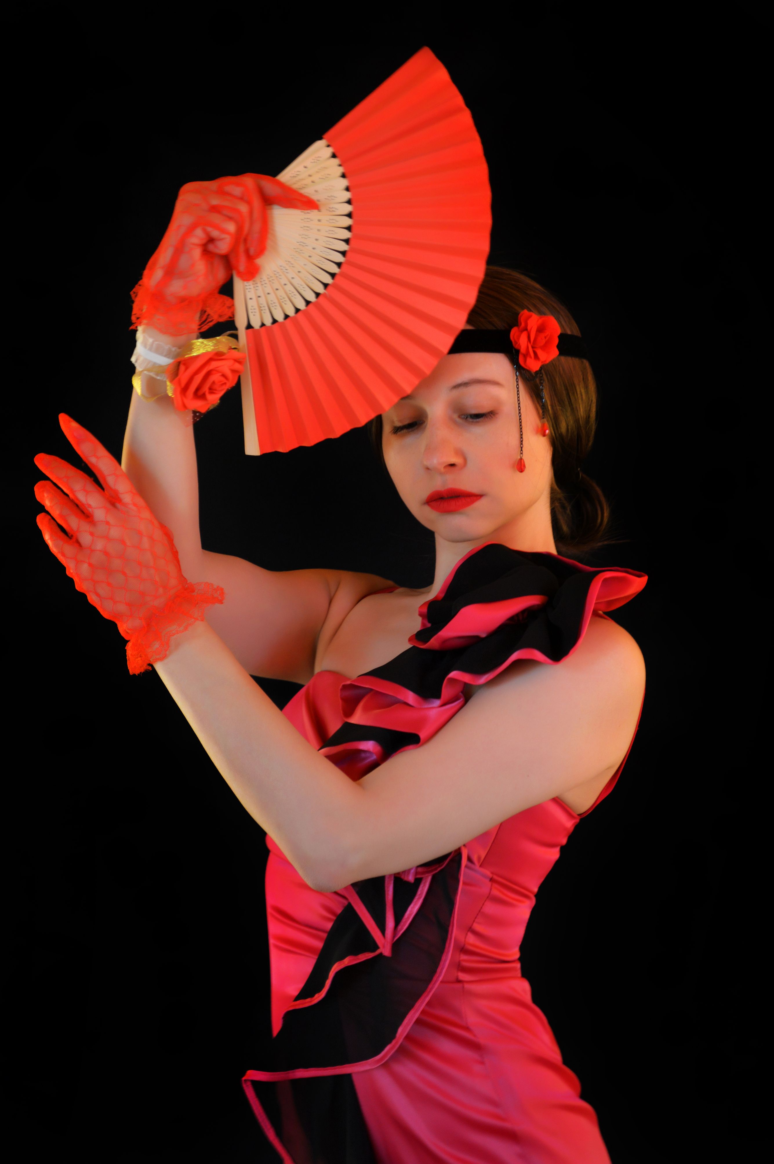 Flamenco dancer in bright costume standing against black background ...