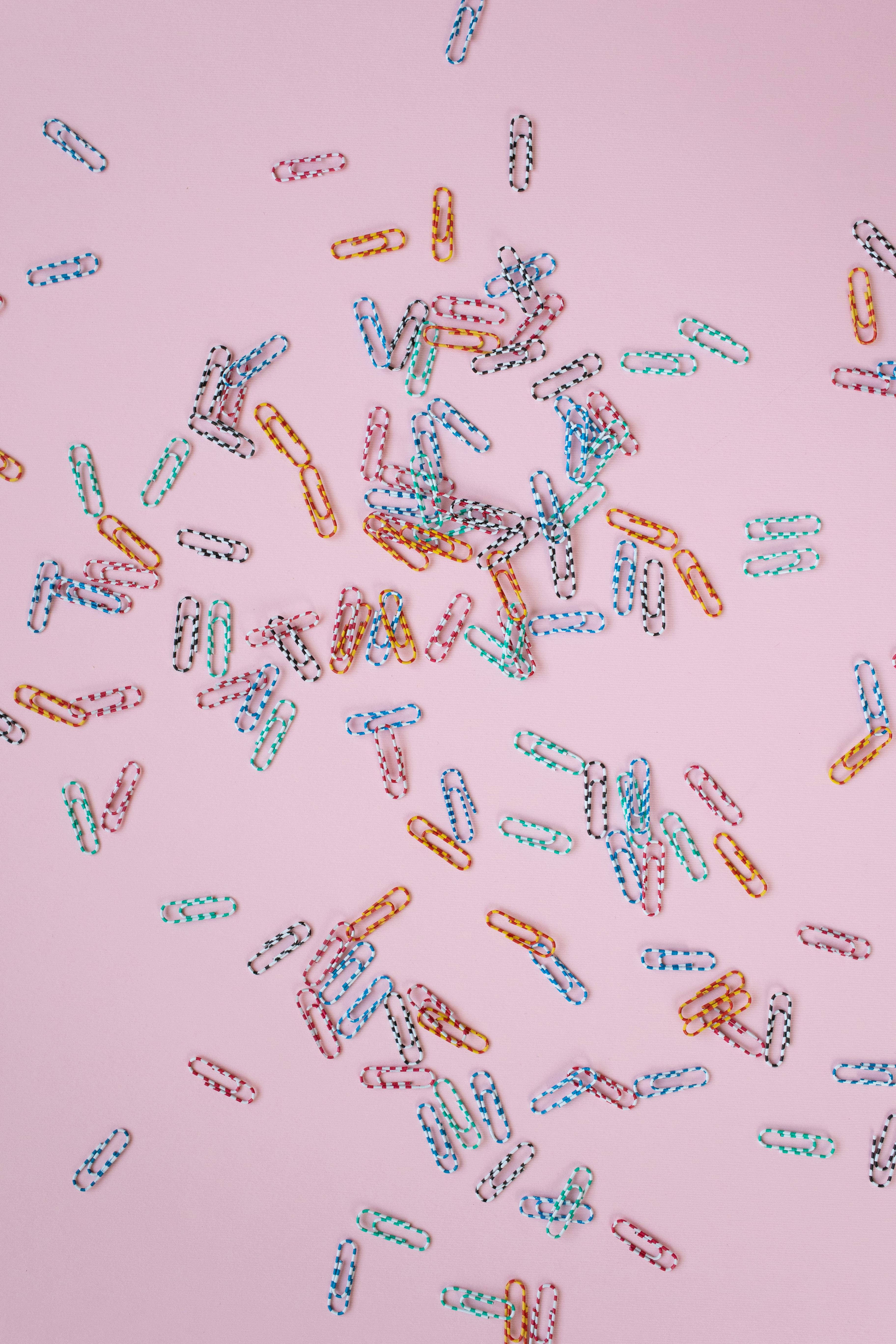 Striped Paper Clips on a Pink Surface · Free Stock Photo