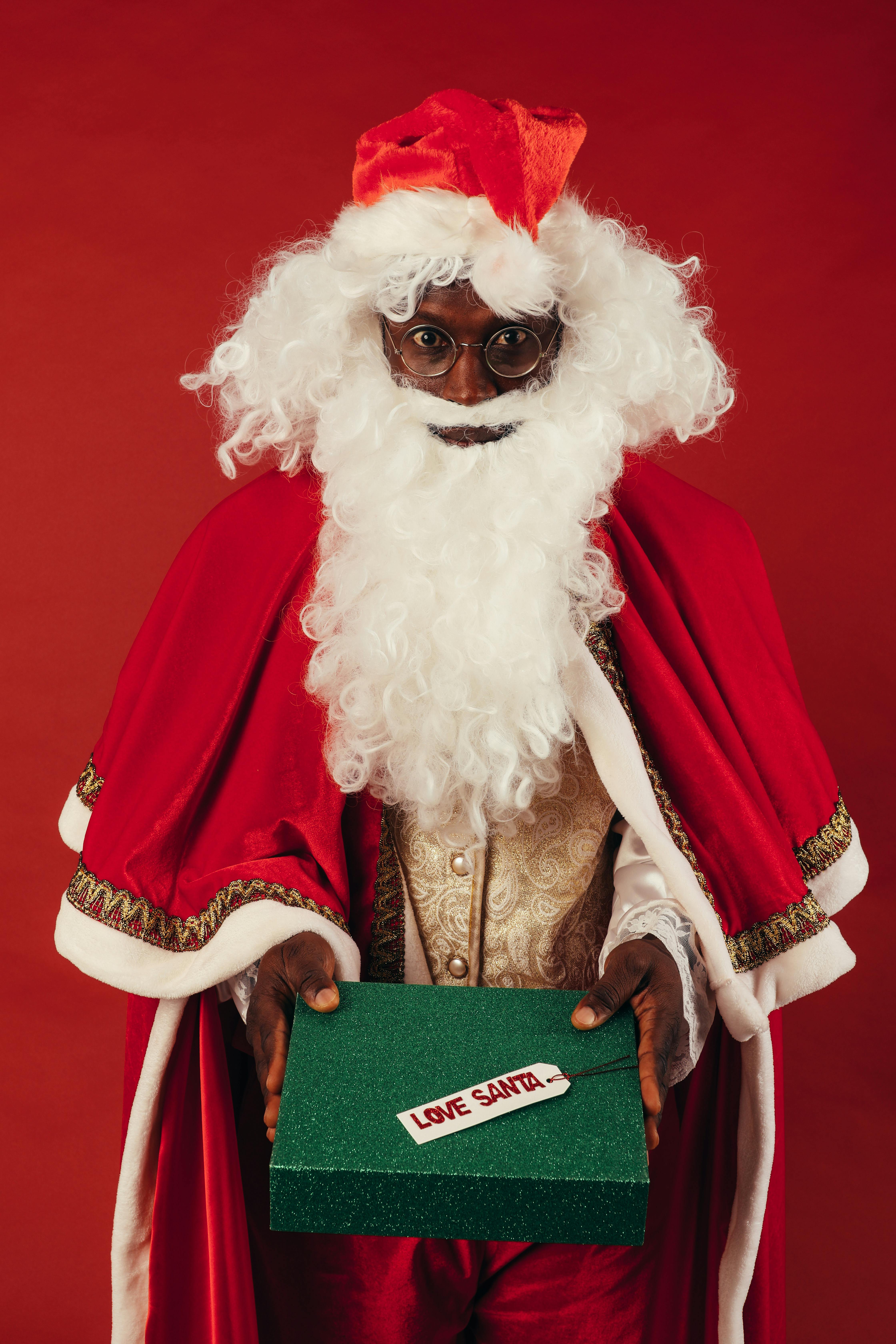 Person In Santa Outfit Holding A Gift Box · Free Stock Photo